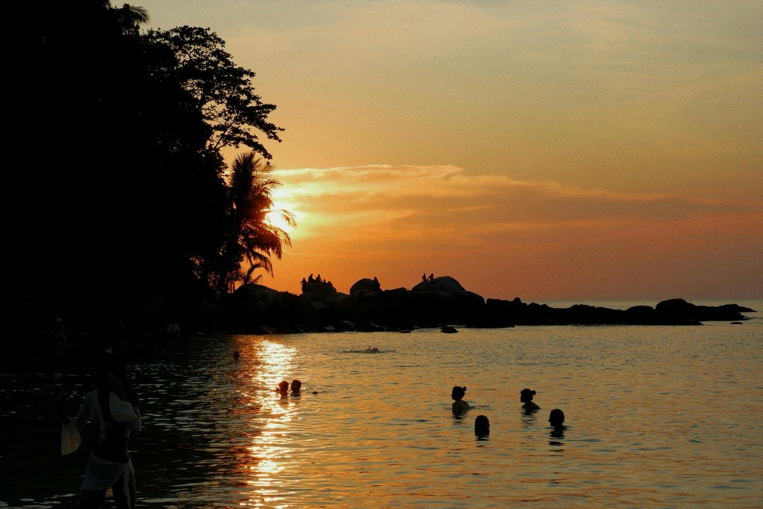 Atardecer Sereno En La Playa Con Siluetas De Nadadores · Foto de stock ...