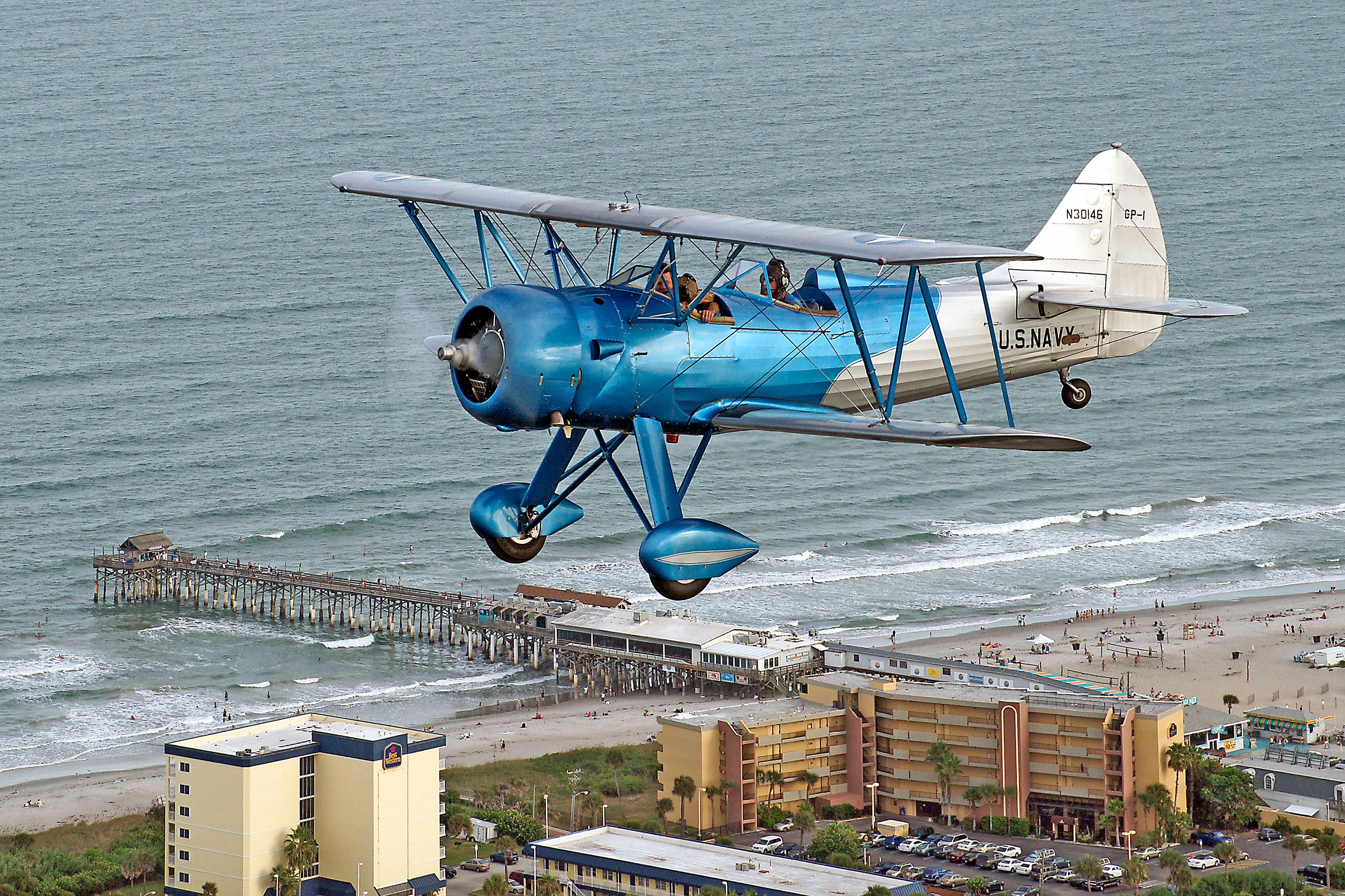 Vintage Biplane Flying Over Cocoa Beach Pier · Free Stock Photo