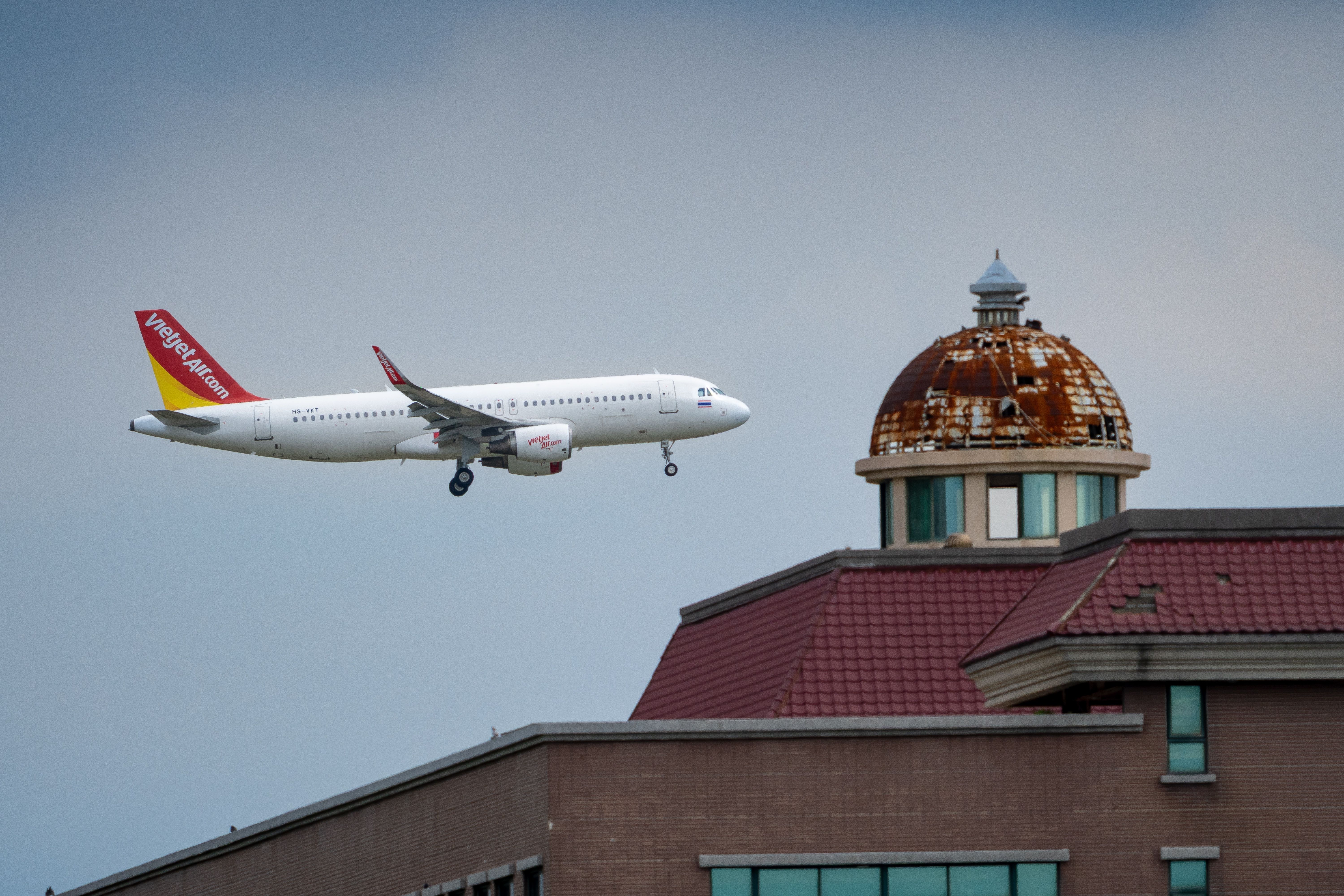 Airplane Approaching Urban Building · Free Stock Photo