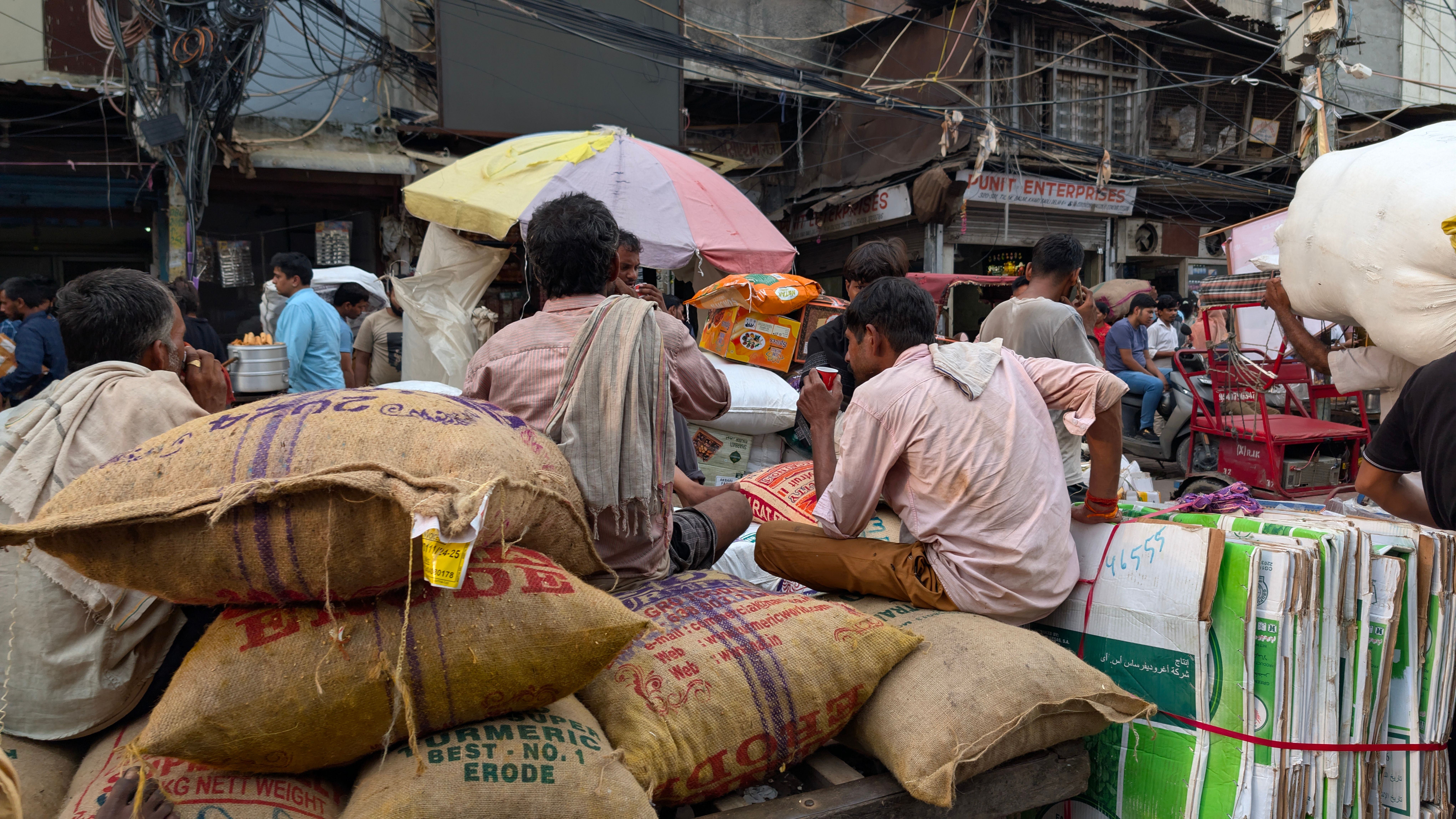 Laborers Rest Amidst Bustling Delhi Street Life · Free Stock Photo
