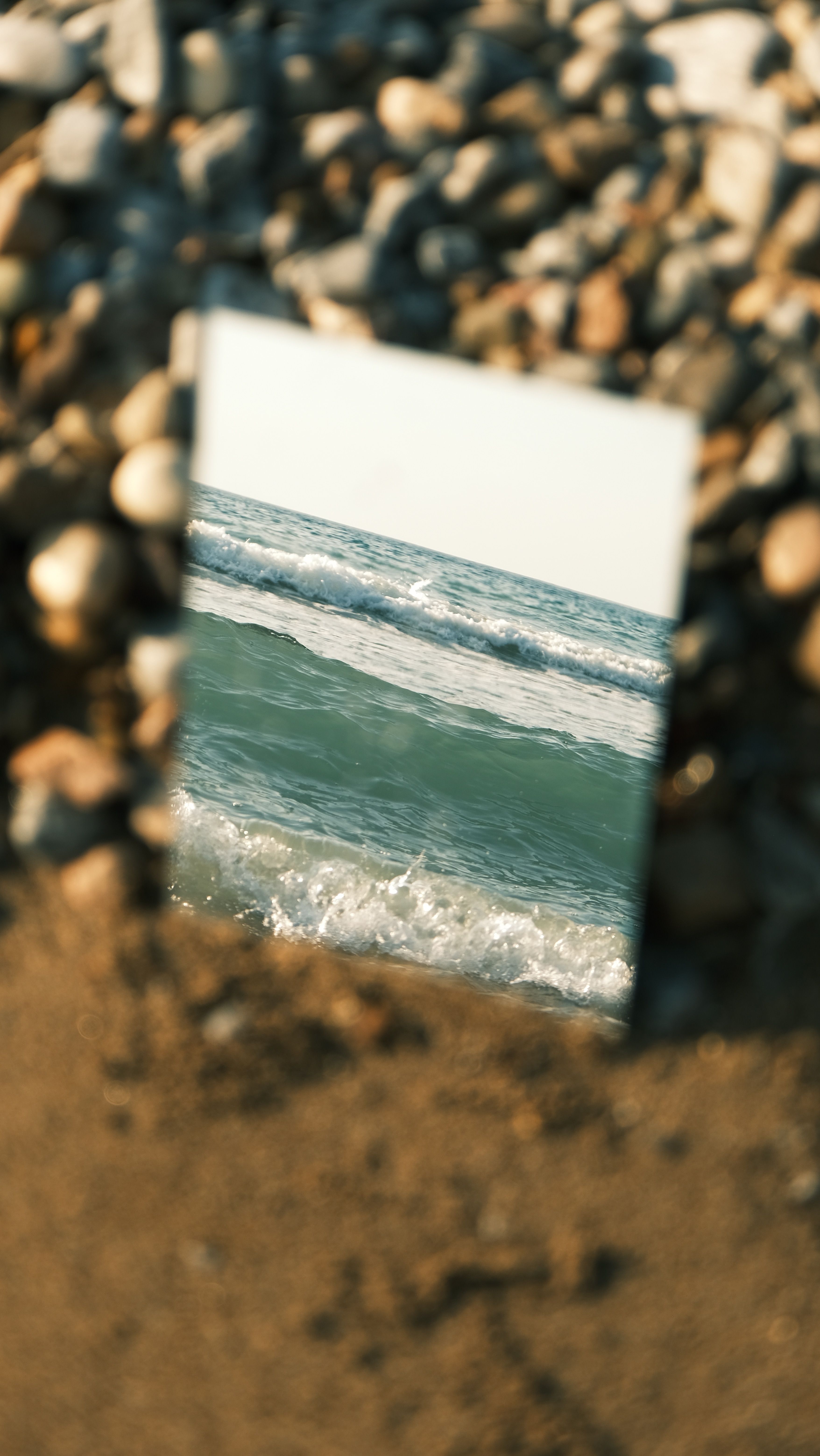 Captivating Beach Reflection in a Mirror on Pebbles · Free Stock Photo