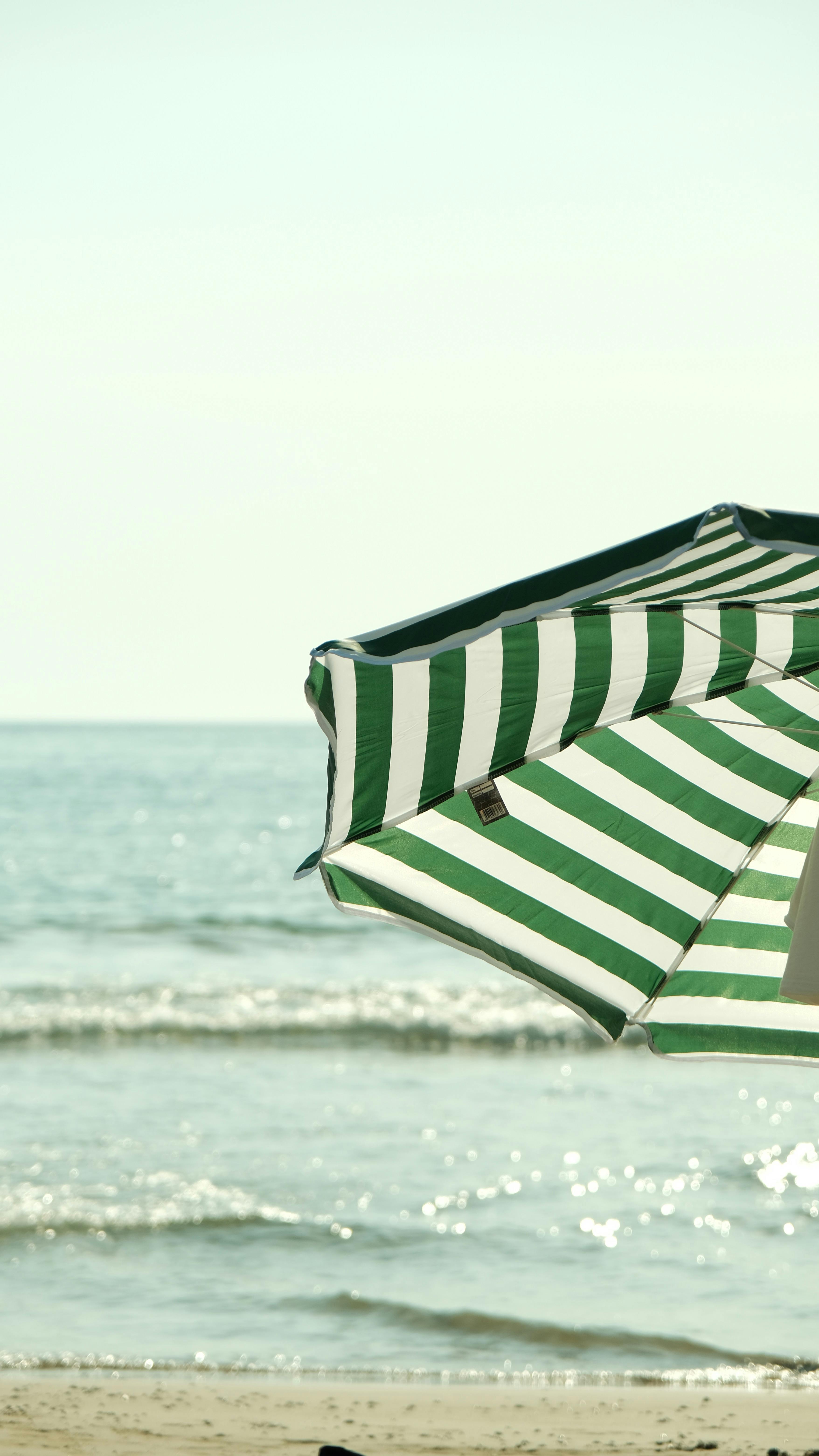Sombrilla De Playa De Rayas Verdes En La Soleada Costa · Foto de stock ...
