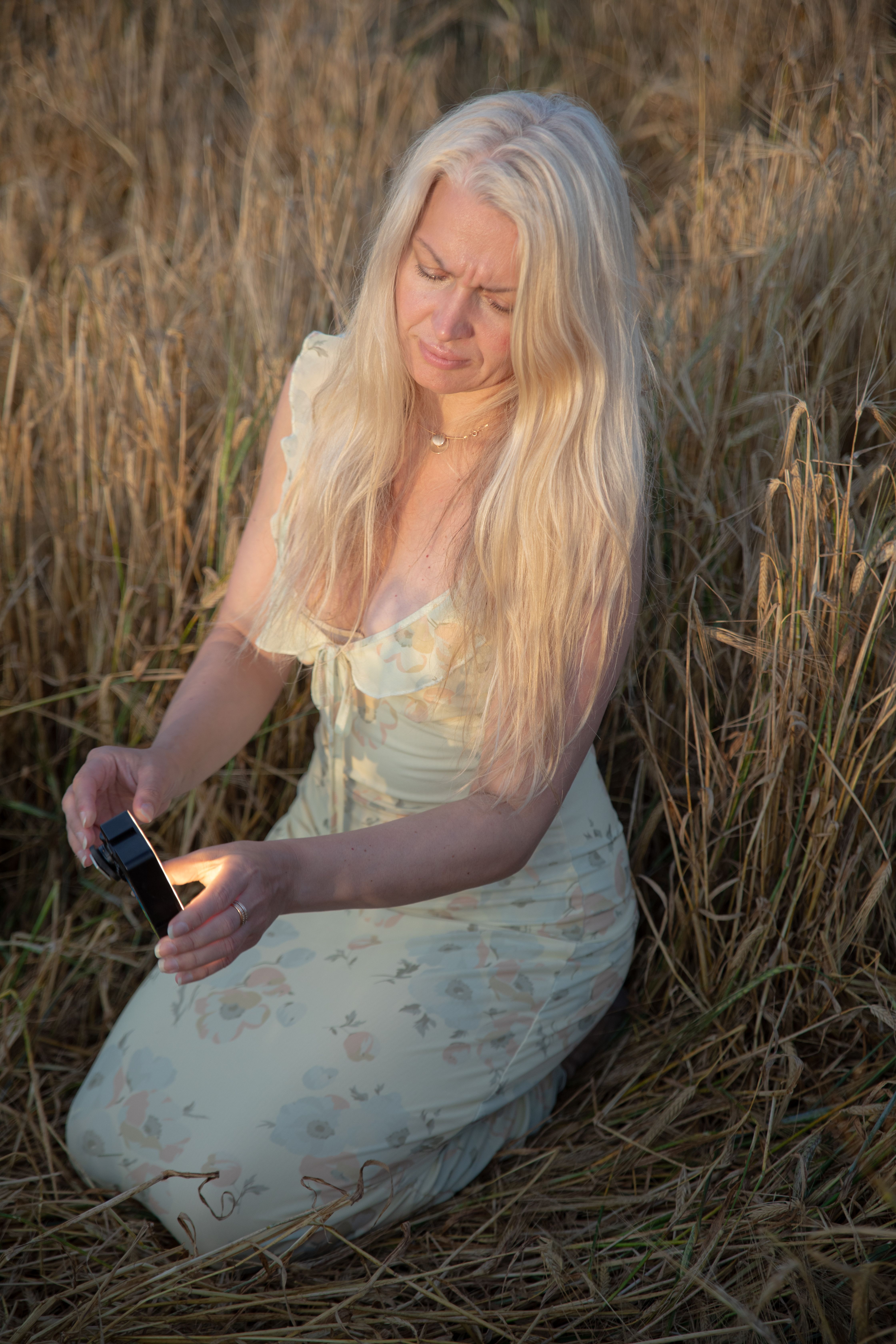 Woman with Smartphone in Wheat Field at Sunset · Free Stock Photo