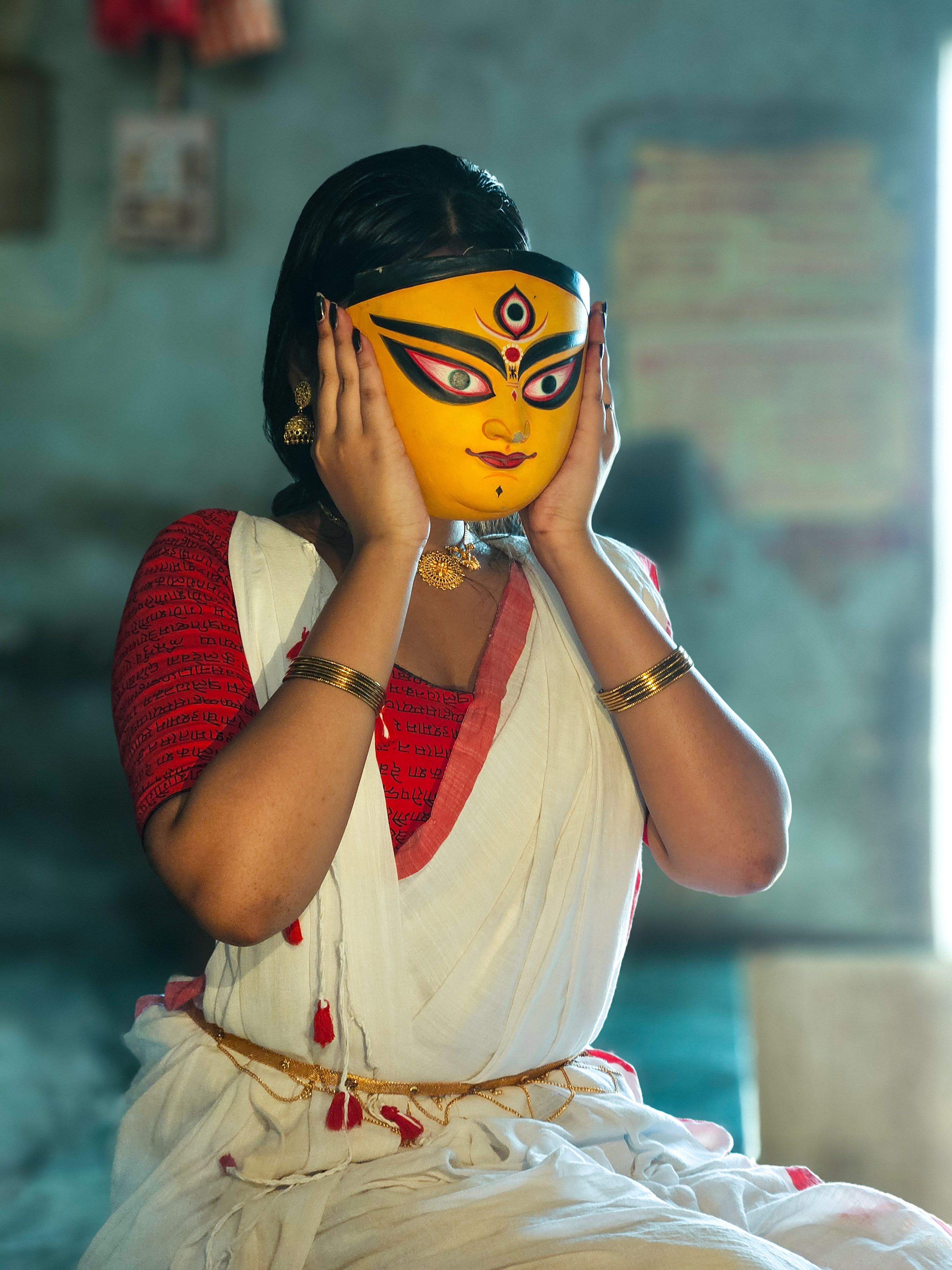 Woman Holding Traditional Goddess Mask Indoors · Free Stock Photo