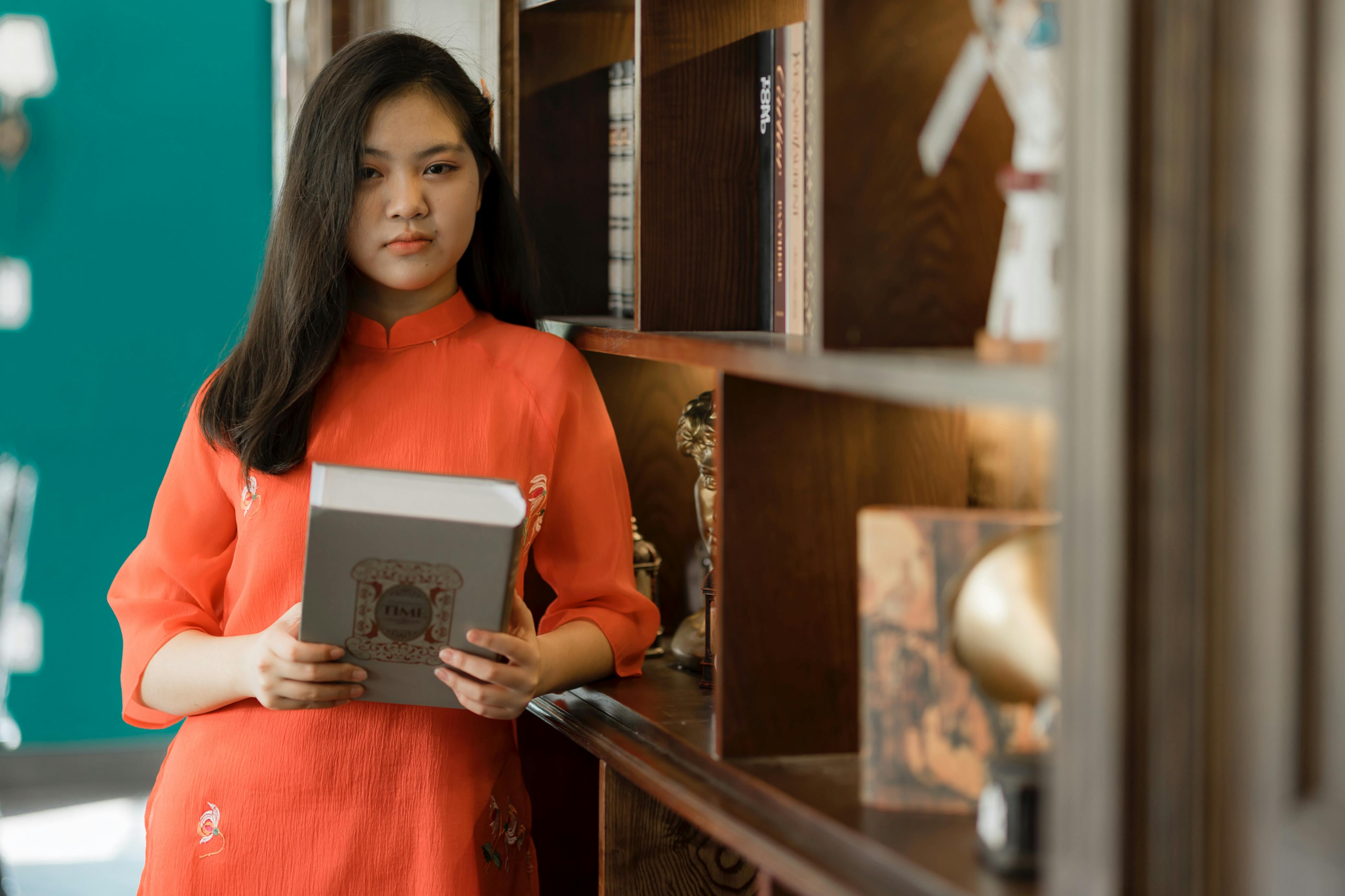 Female Student Reading Business Book in Library · Free Stock Photo