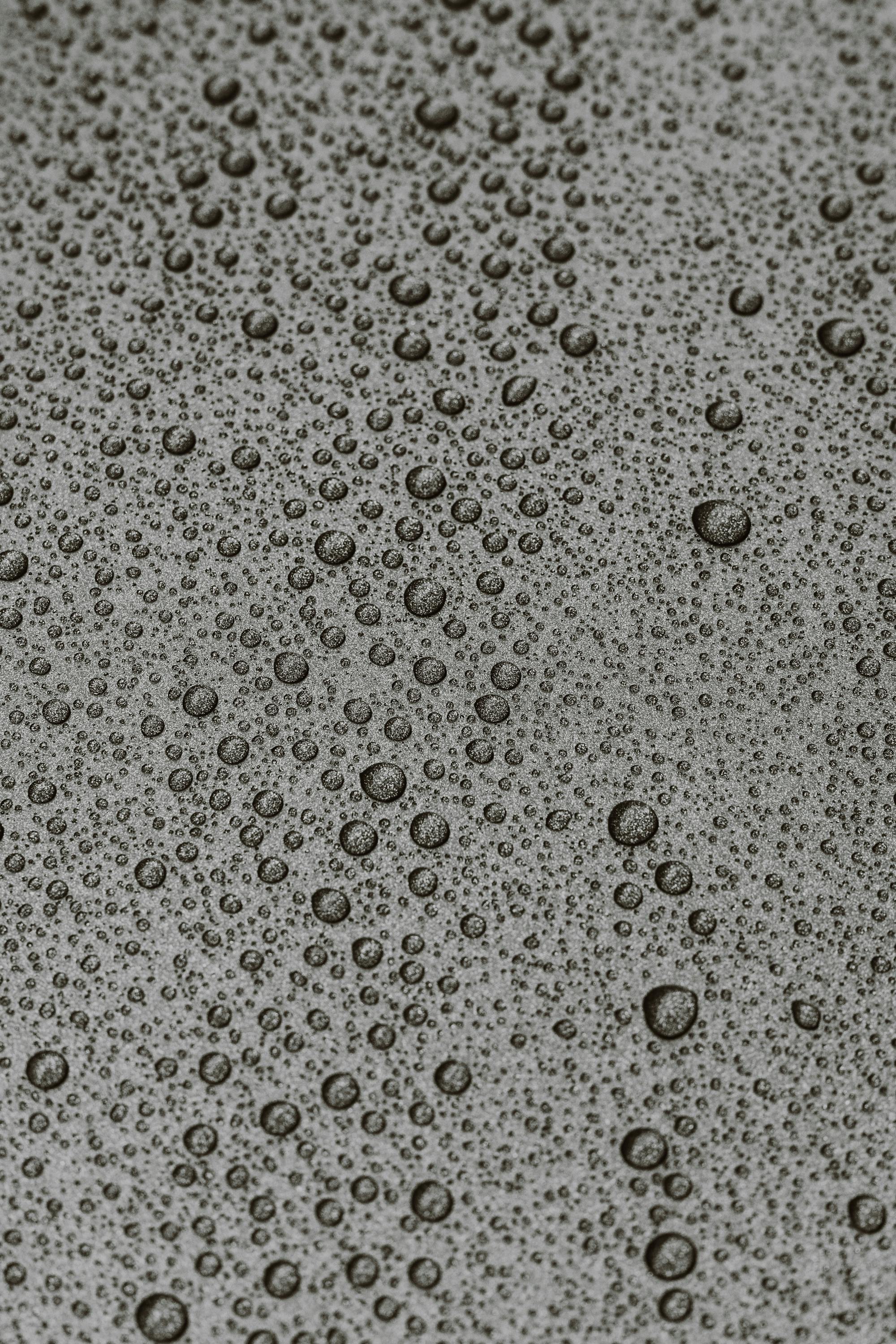 Close-up of Water Droplets on Gray Surface · Free Stock Photo