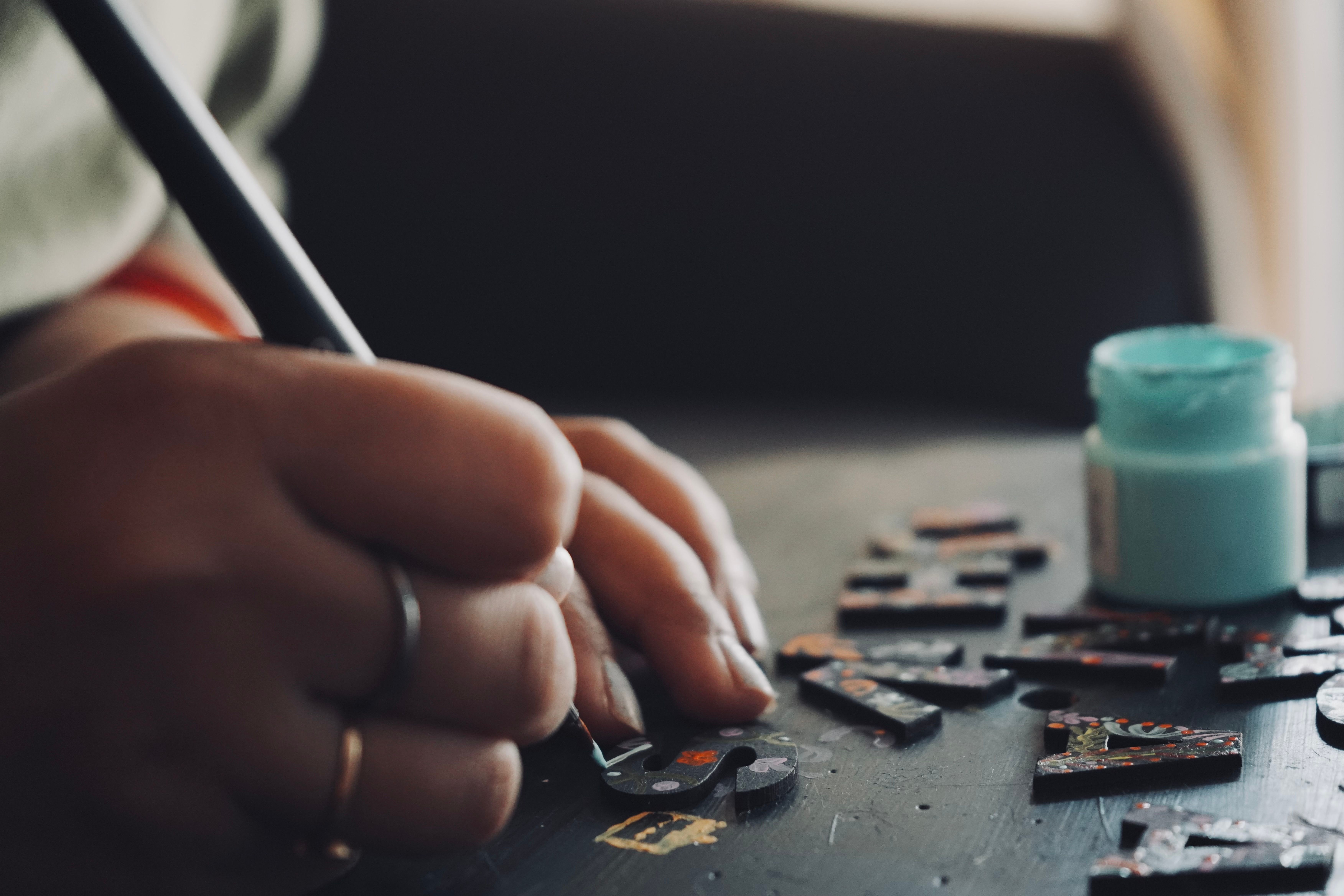 Close-up of Hand Crafting with Paint and Puzzle Pieces · Free Stock Photo