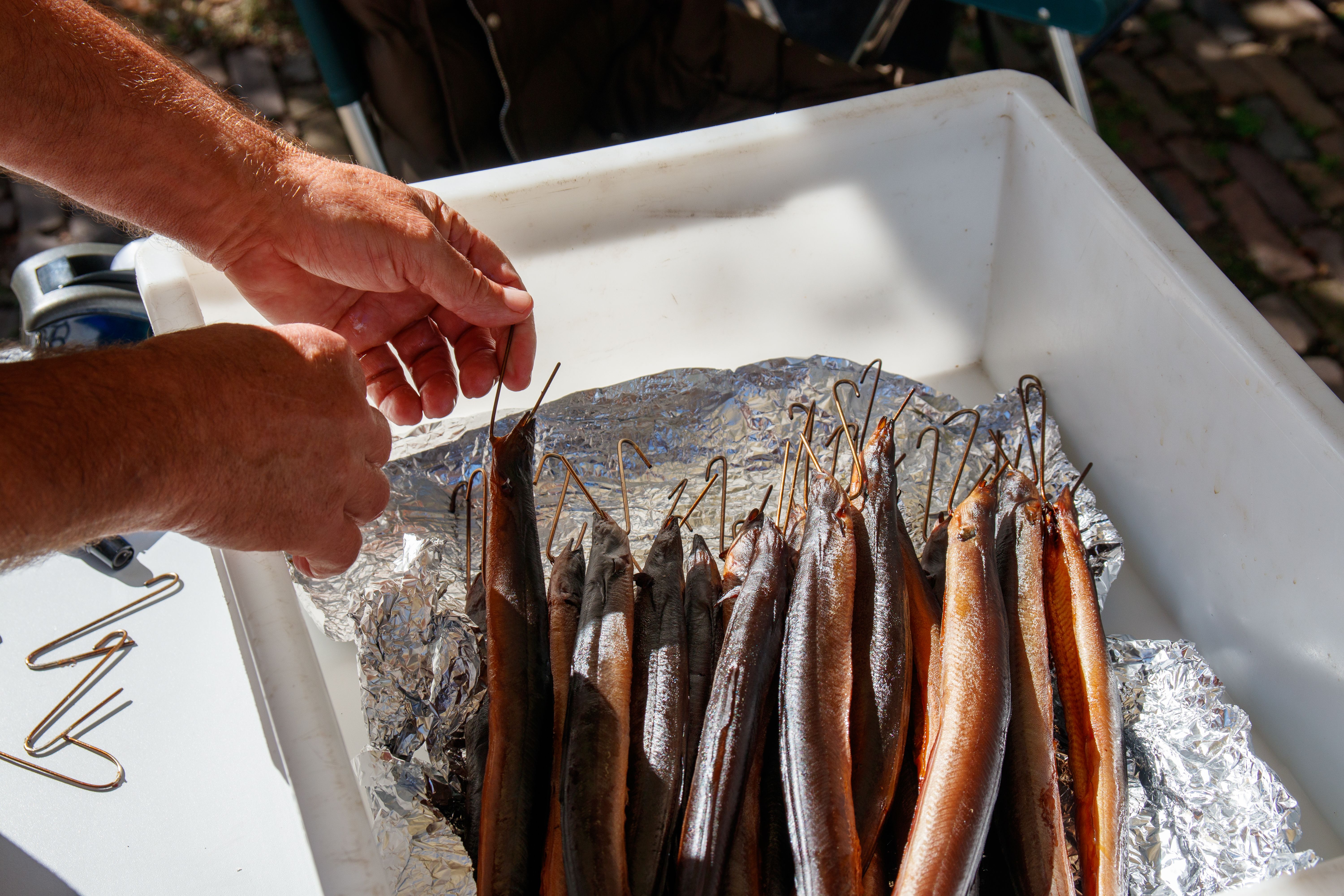 Hands Preparing Smoked Fish Outdoors · Free Stock Photo
