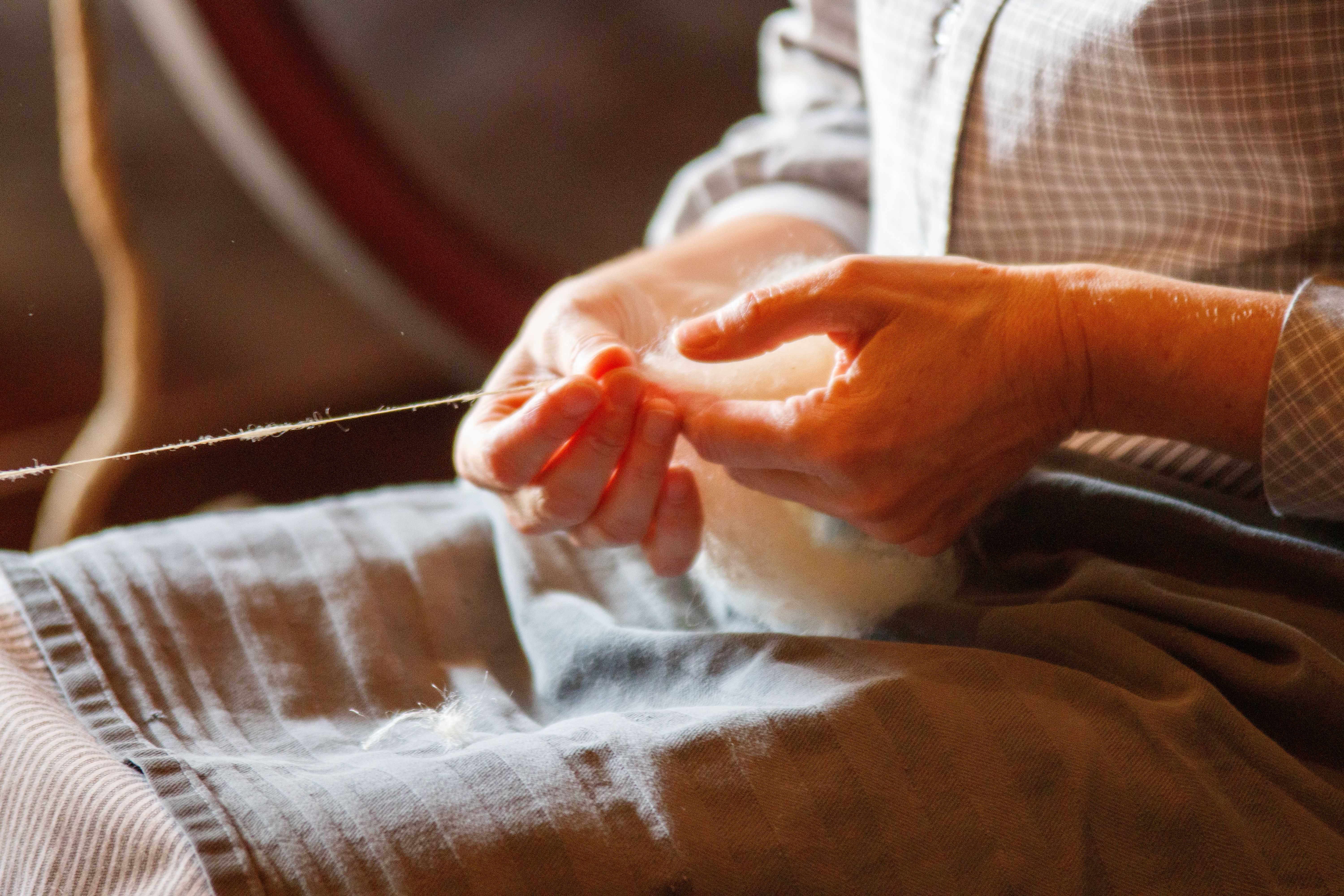 Close-up of hands spinning wool into yarn · Free Stock Photo