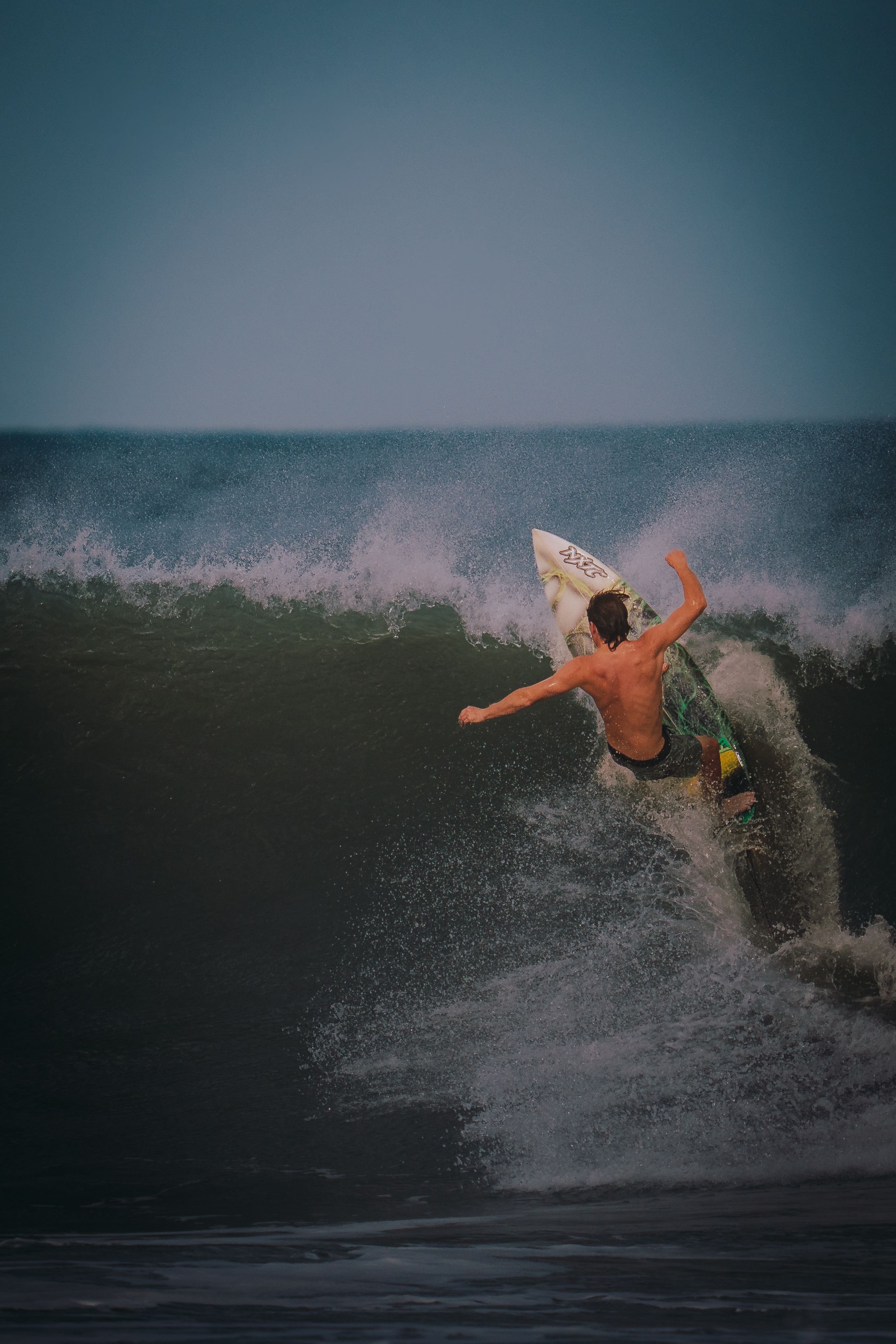 Dynamic Action Shot of Surfer Riding Ocean Wave · Free Stock Photo