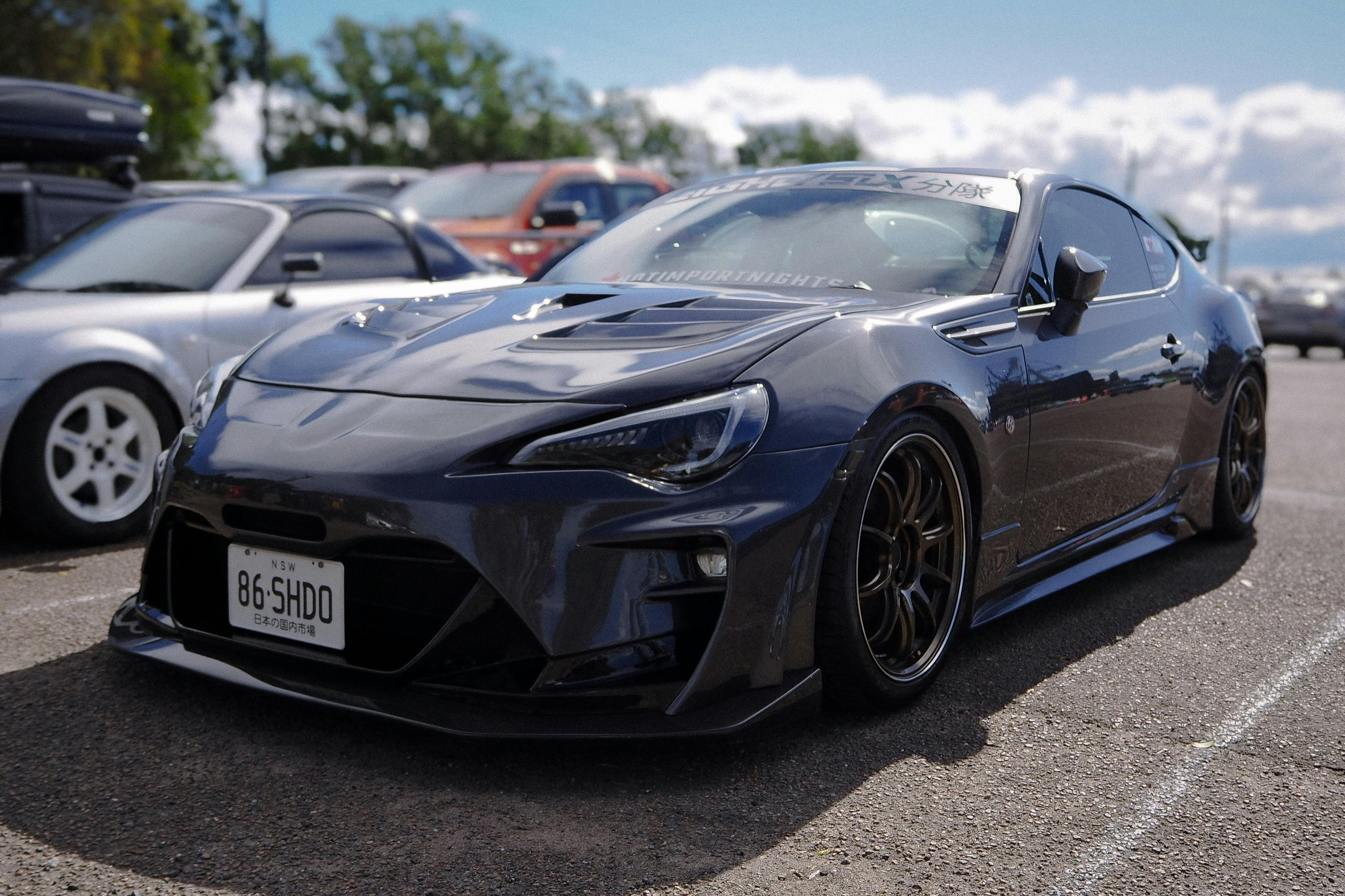 Sleek Black JDM Car at Outdoor Auto Show · Free Stock Photo