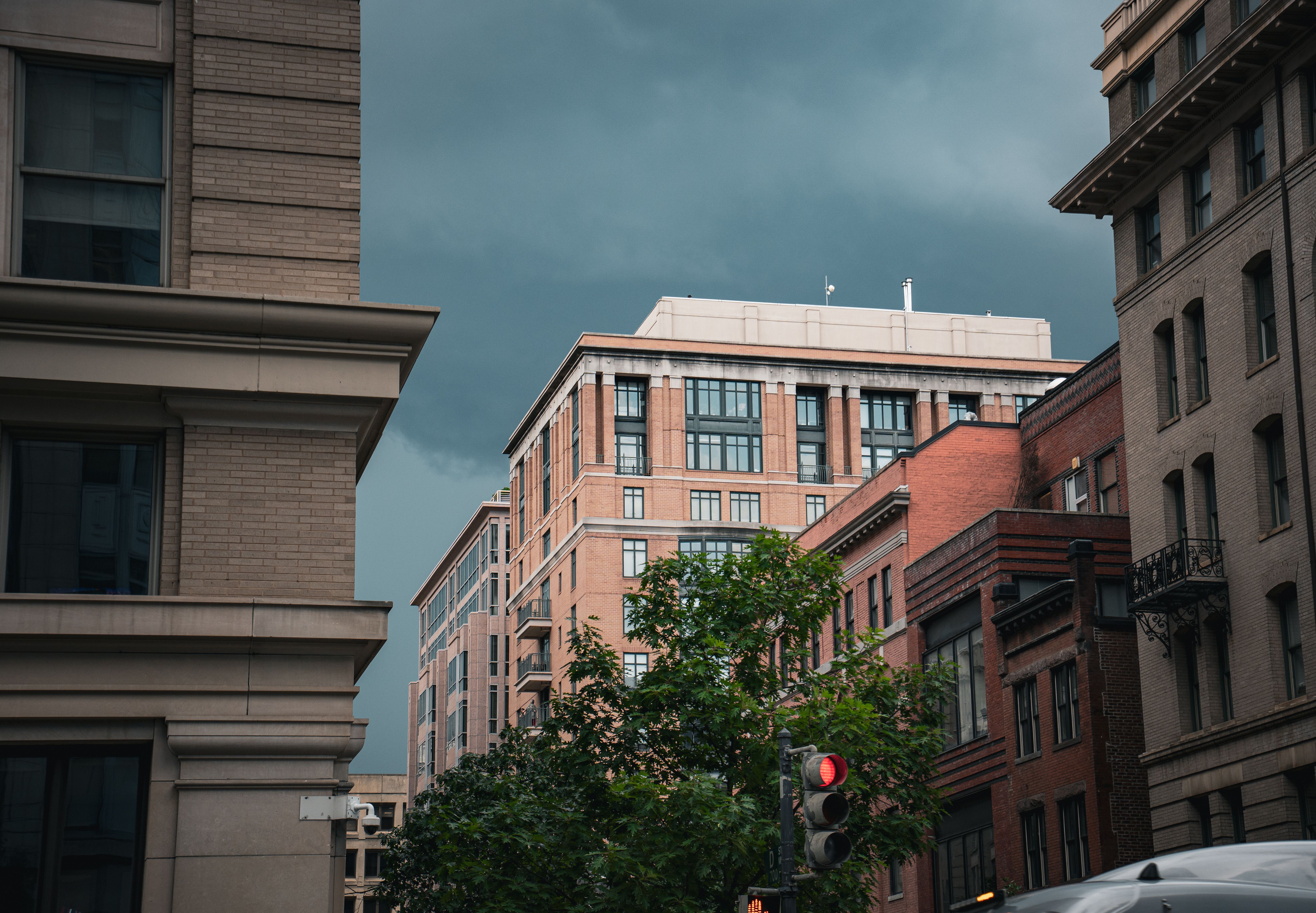 Dramatic Cityscape with Brick Buildings and Overcast Sky · Free Stock Photo