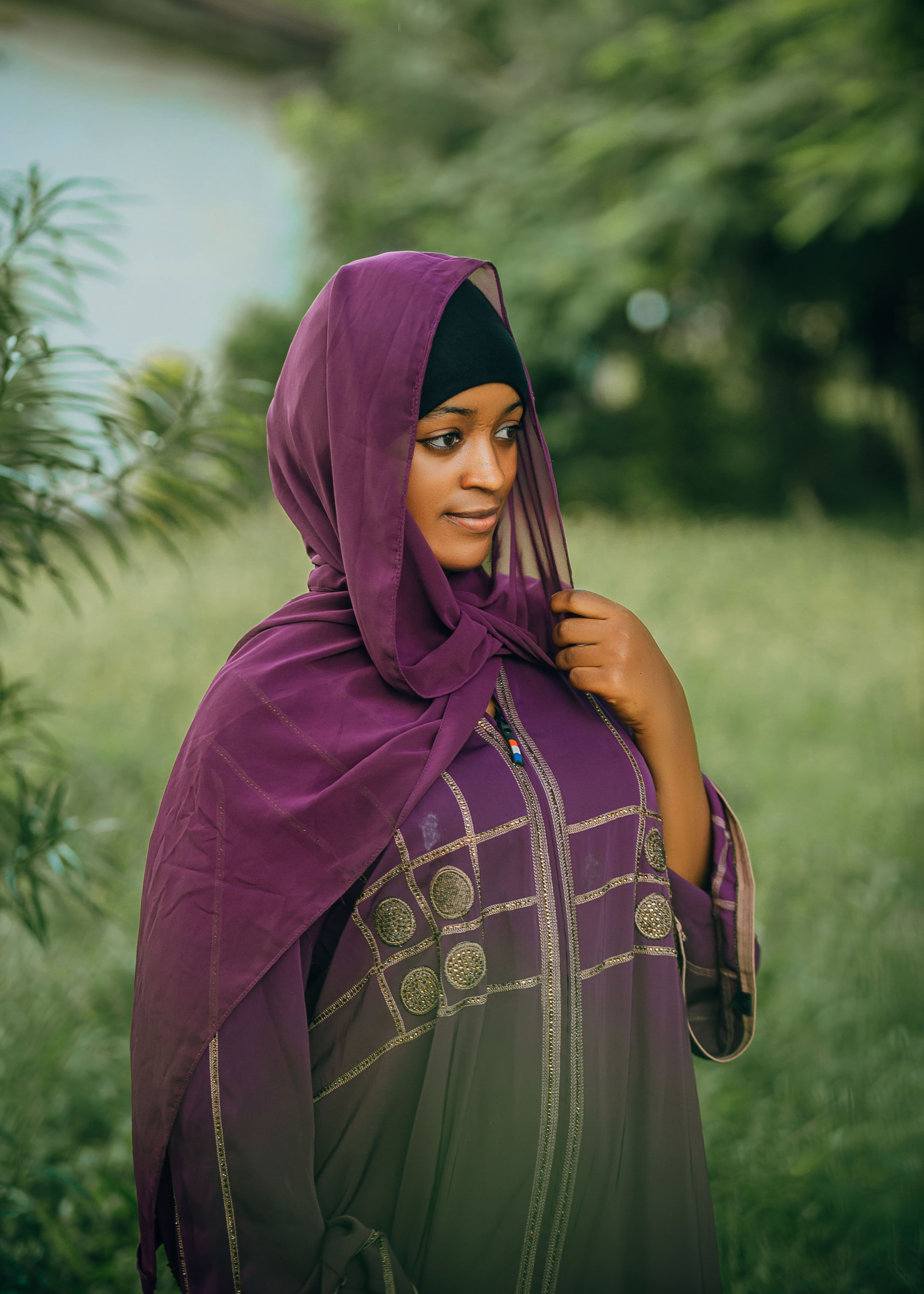 Smiling Woman in Purple Hijab by a Lake · Free Stock Photo