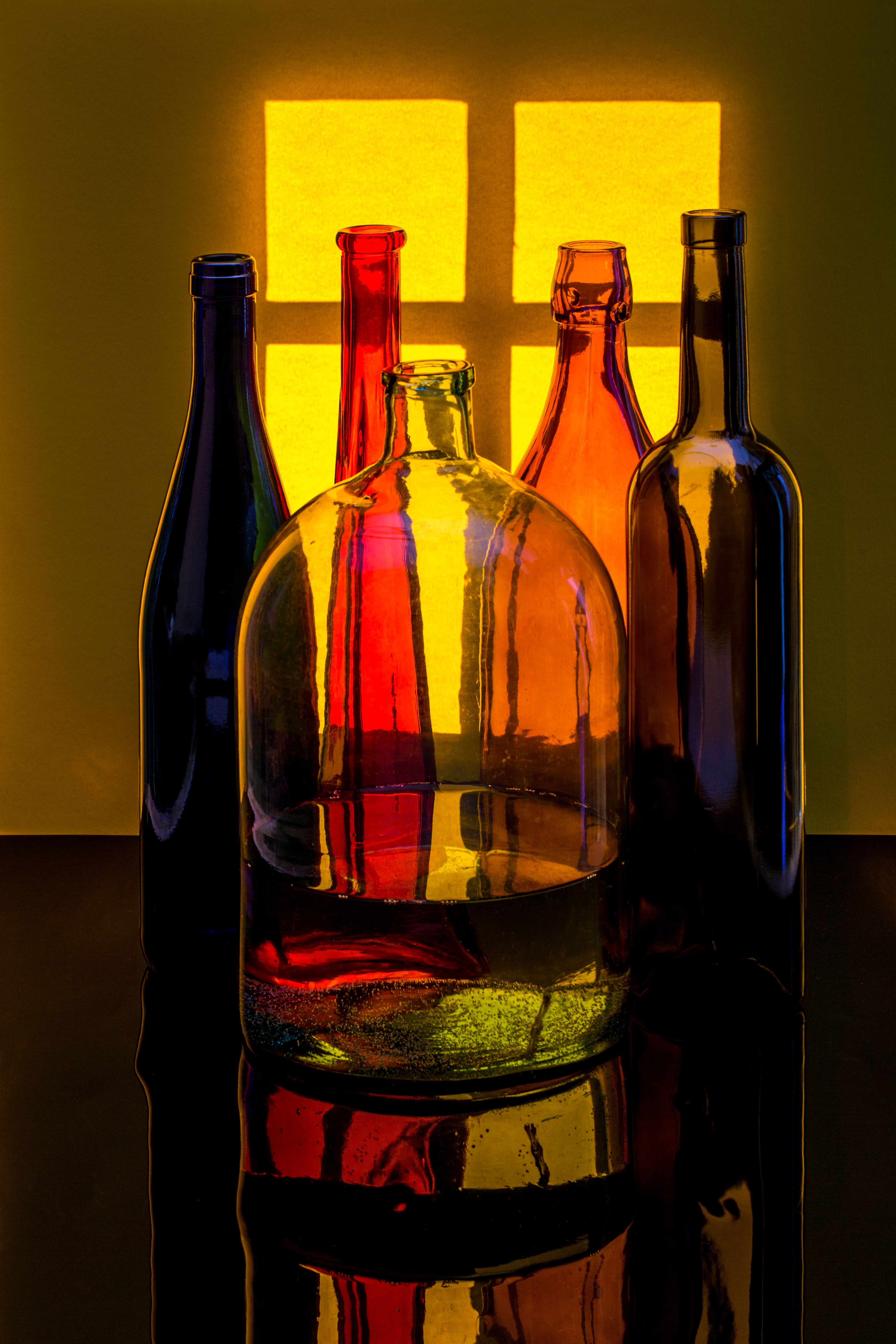 Colorful Glass Bottles with Reflective Surface · Free Stock Photo