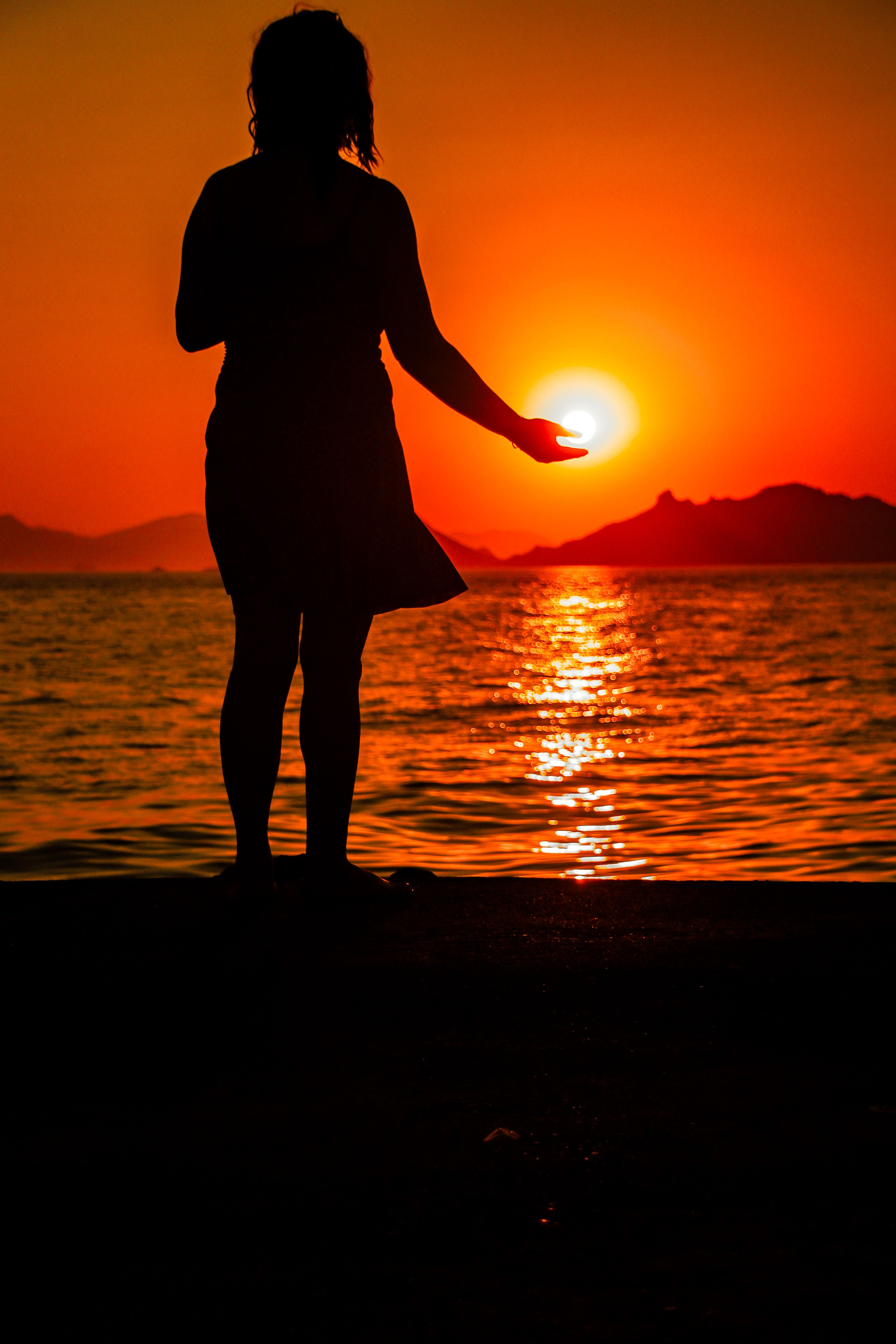 Woman Standing on Beach during Sunset · Free Stock Photo