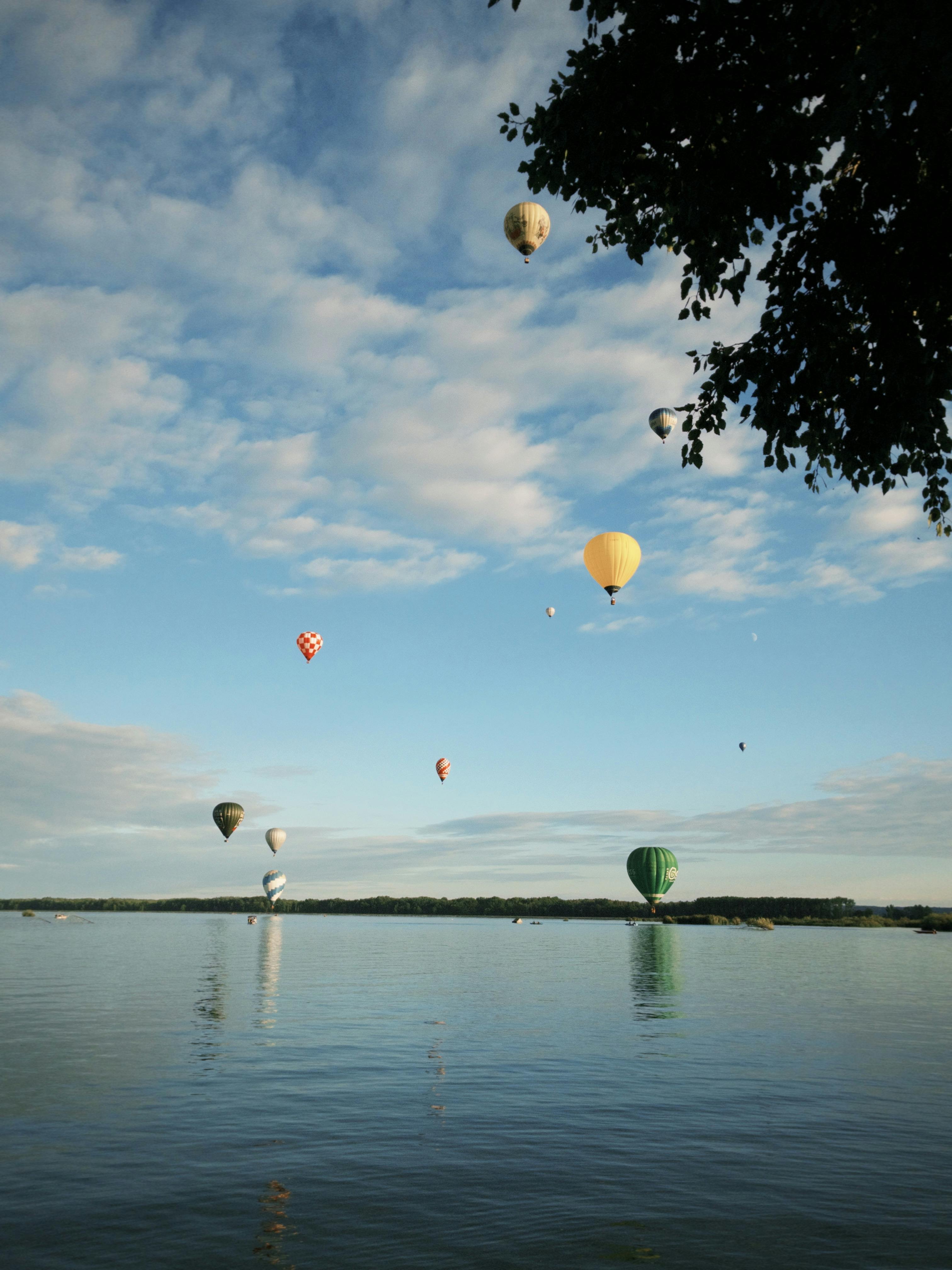 Colorful Hot Air Balloons over Serene Lake · Free Stock Photo