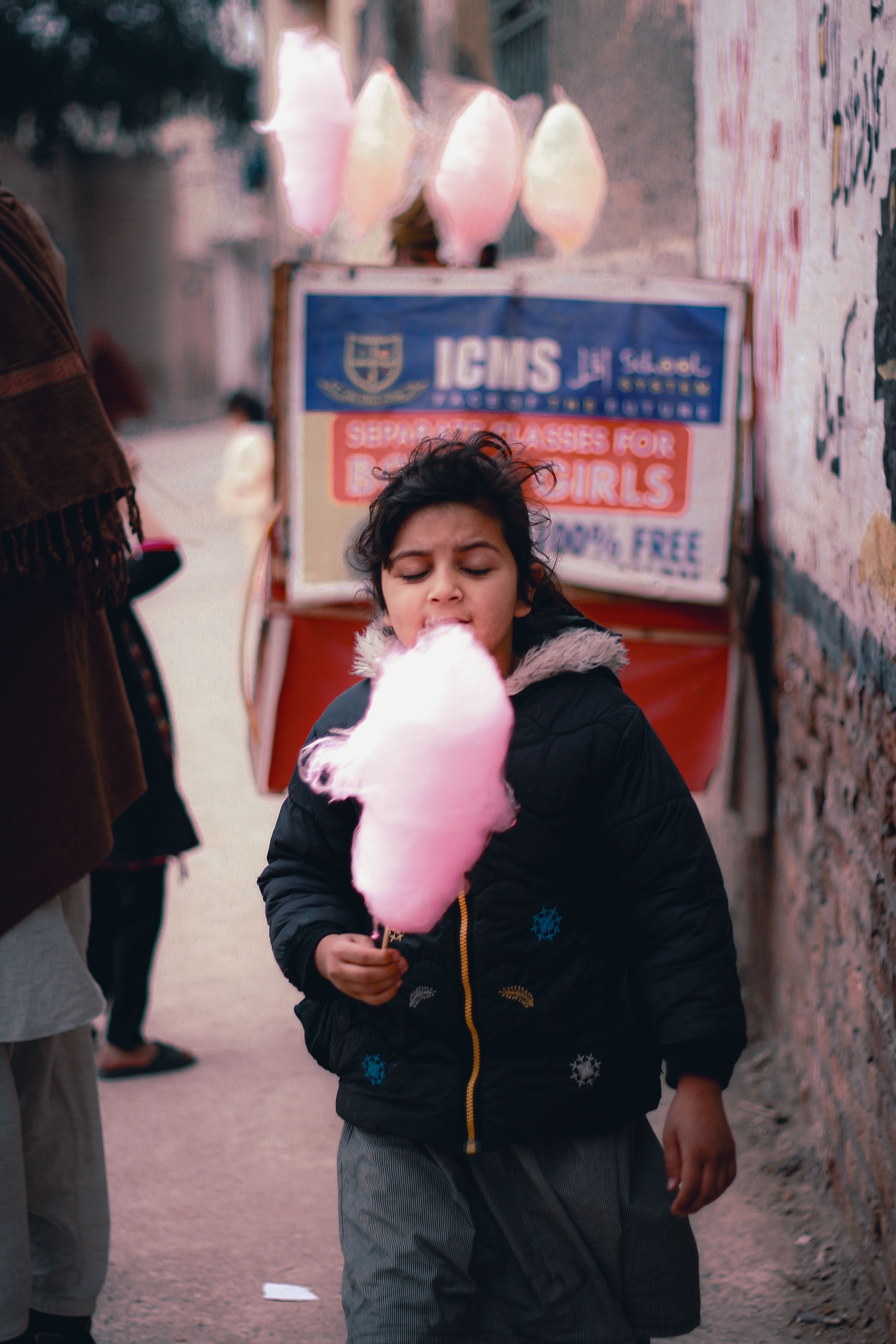Child Enjoying Pink Cotton Candy on a Street · Free Stock Photo