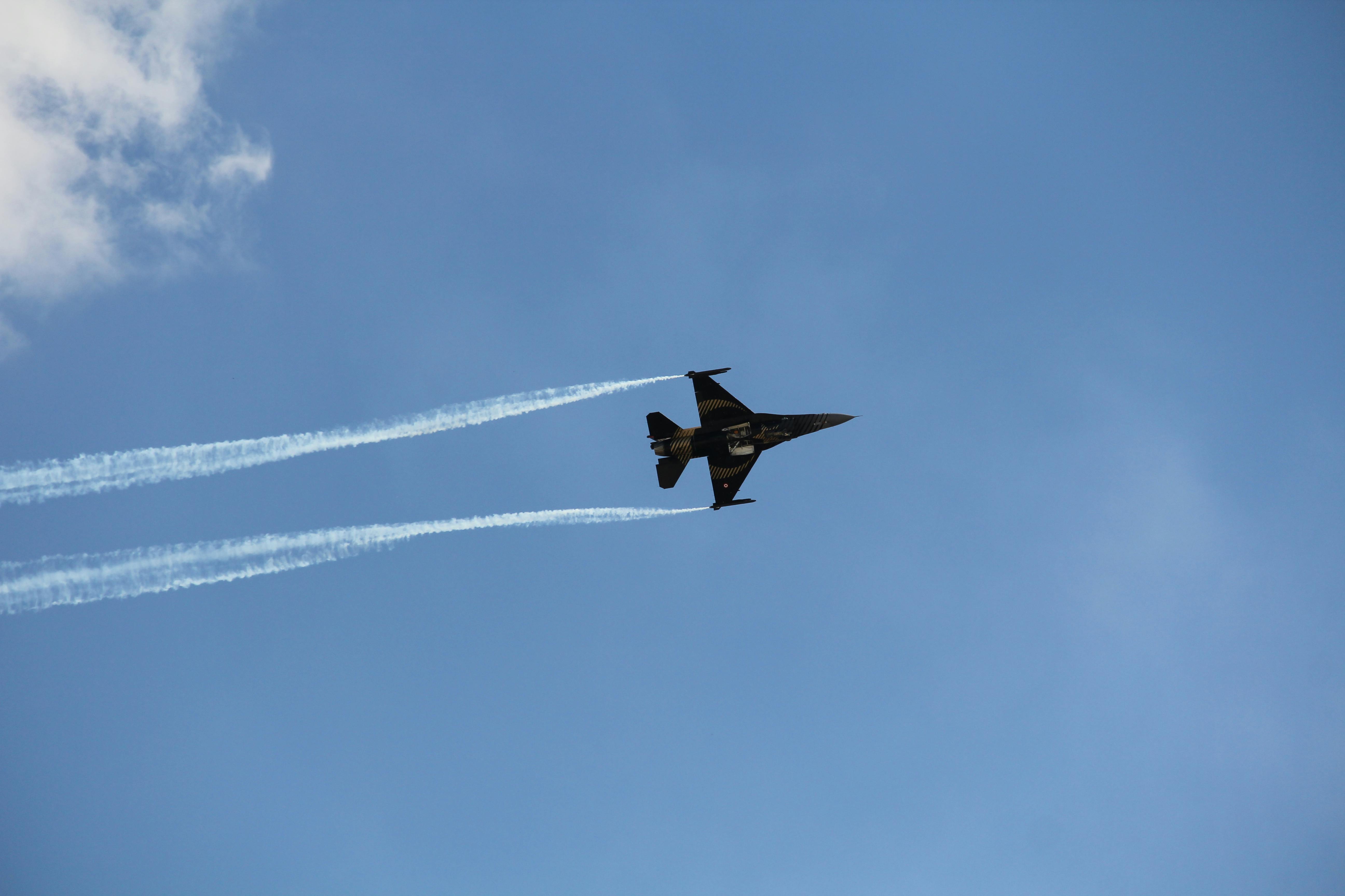 Jet Fighter Performing Stunt Against Blue Sky · Free Stock Photo
