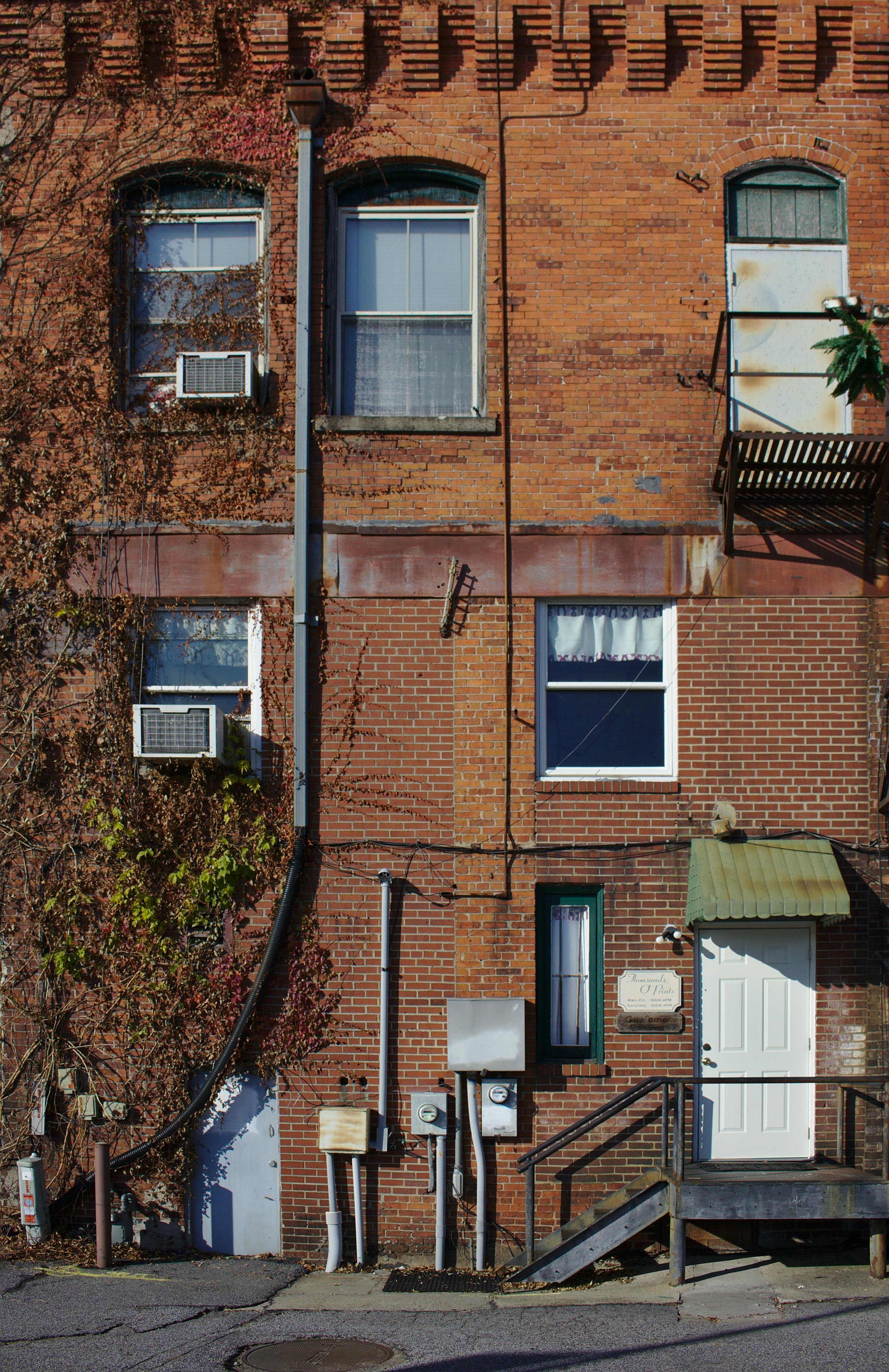Facade of a Red Brick Building with a Street Name Plate · Free Stock Photo
