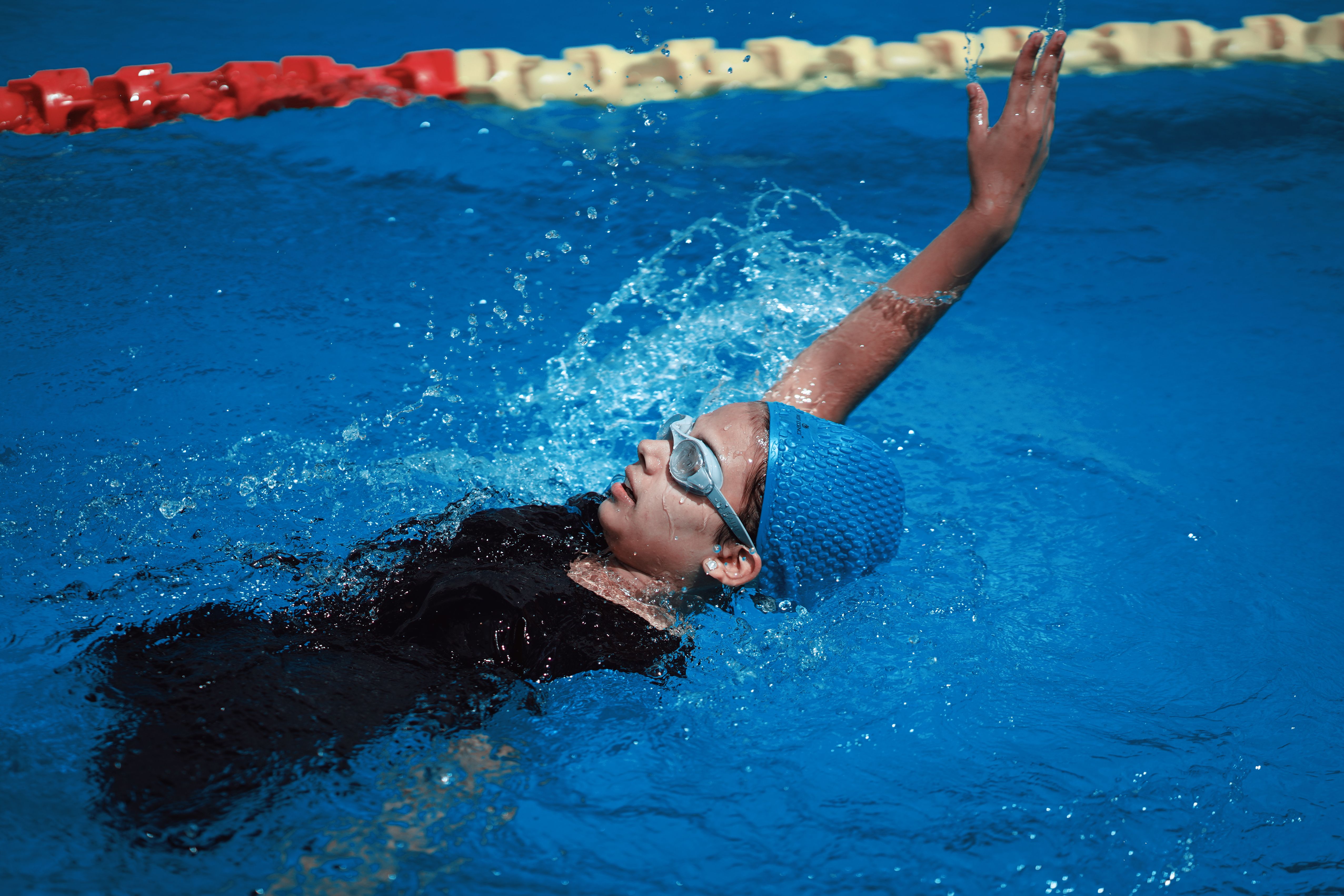 Teen Swimmer Performing Backstroke in Pool · Free Stock Photo