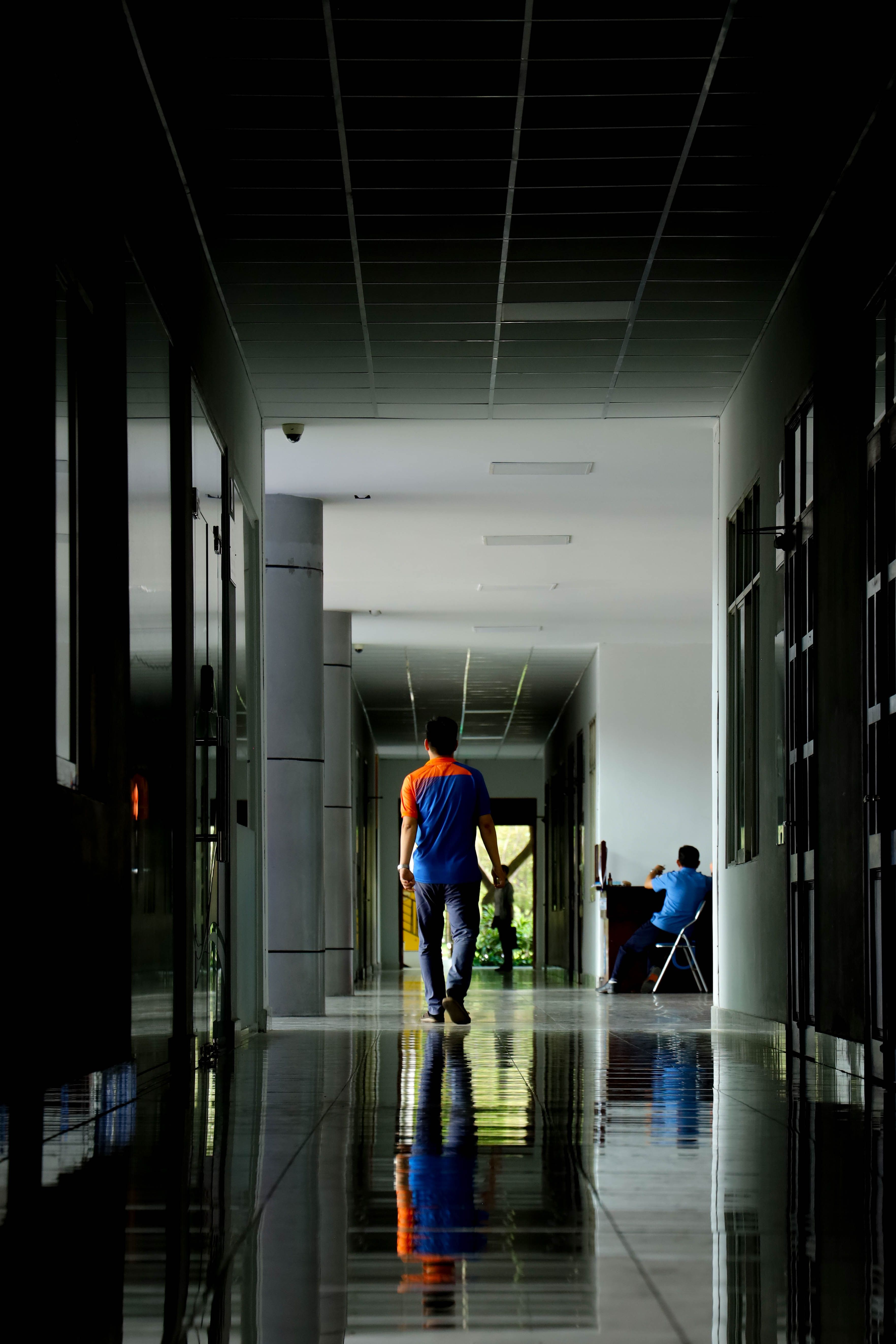 Hallway Reflections with Single Person Walking · Free Stock Photo