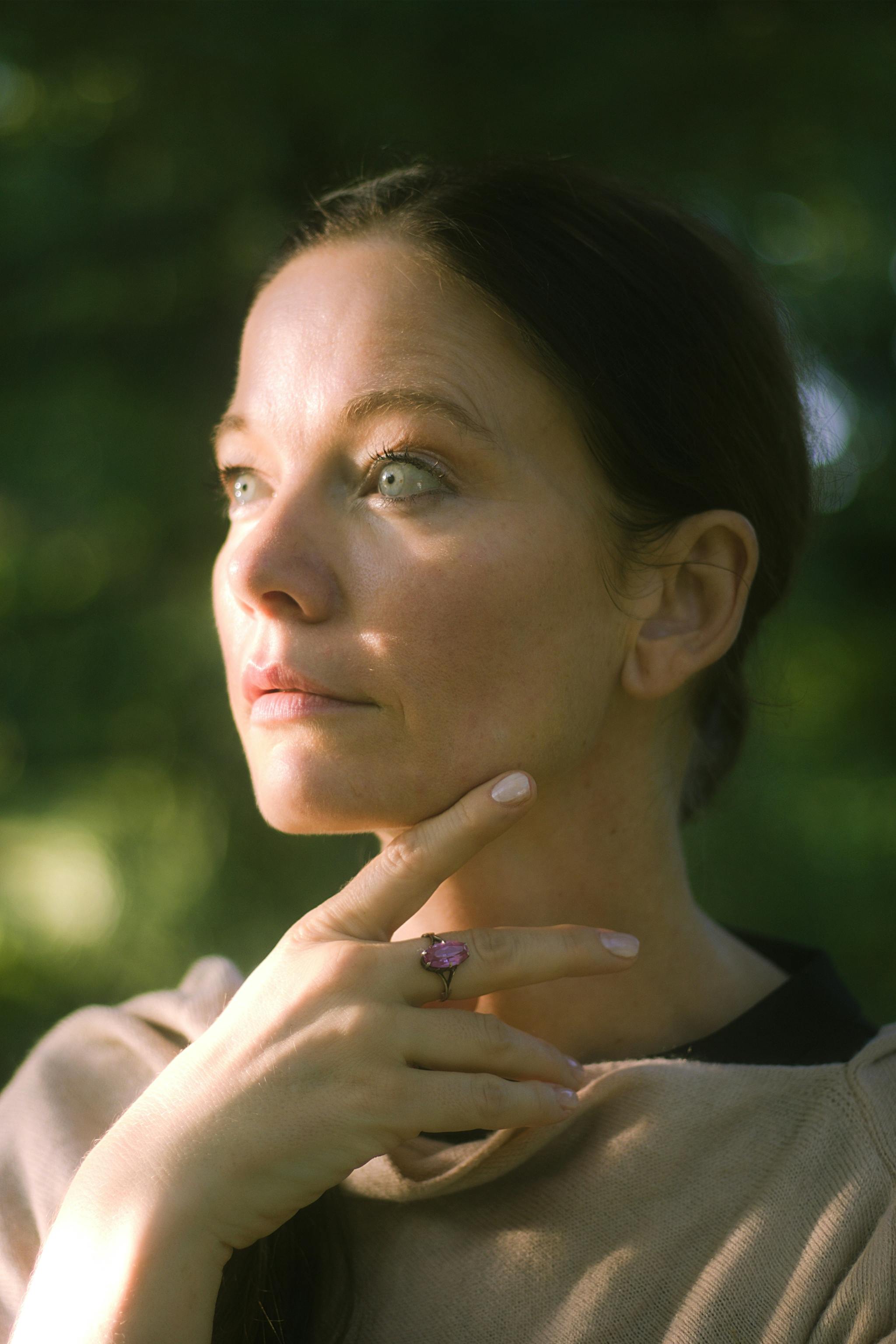 Contemplative Woman in Natural Light Outdoors · Free Stock Photo