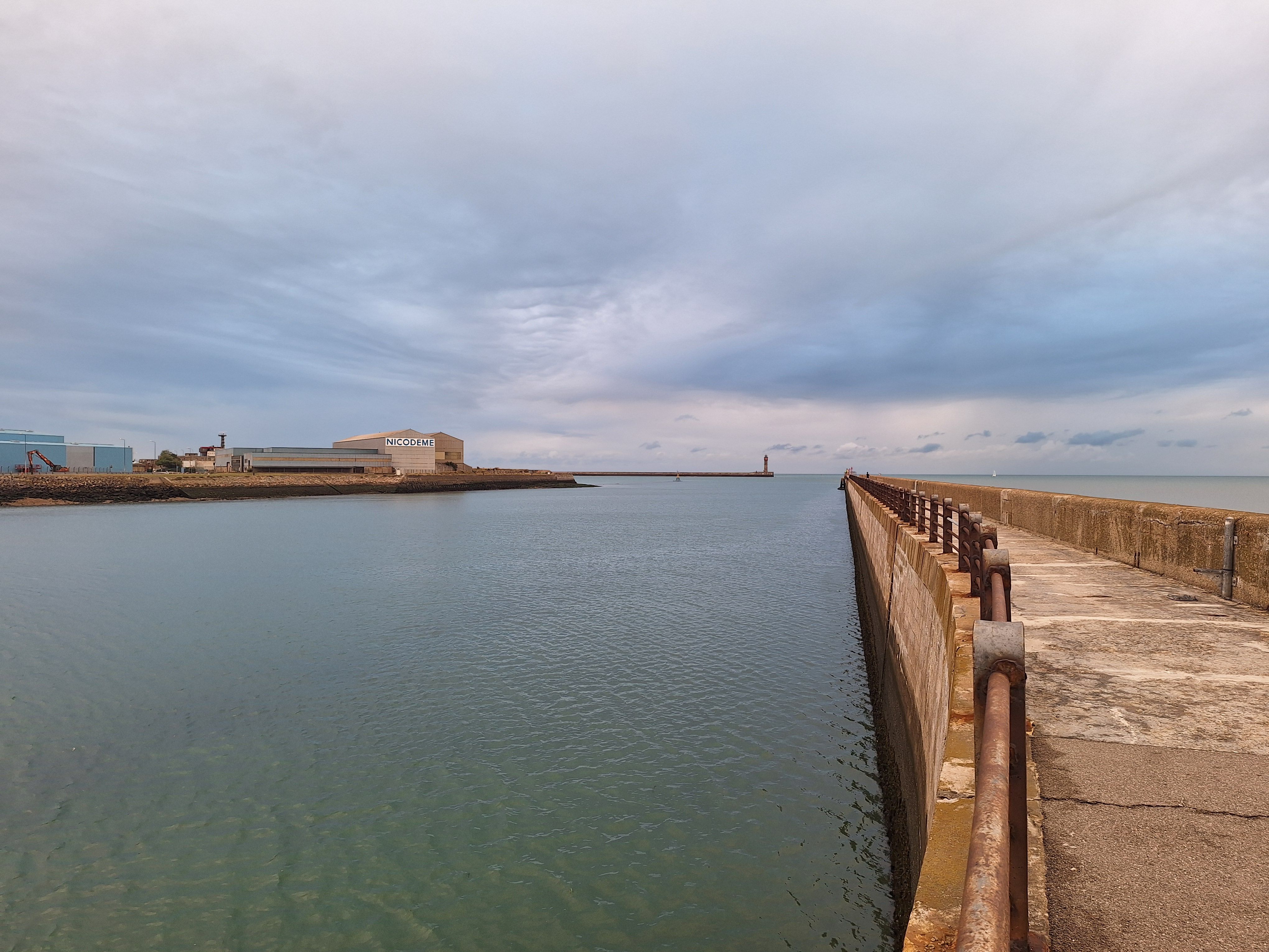 Tranquil Ocean View with Breakwater and Lighthouse · Free Stock Photo