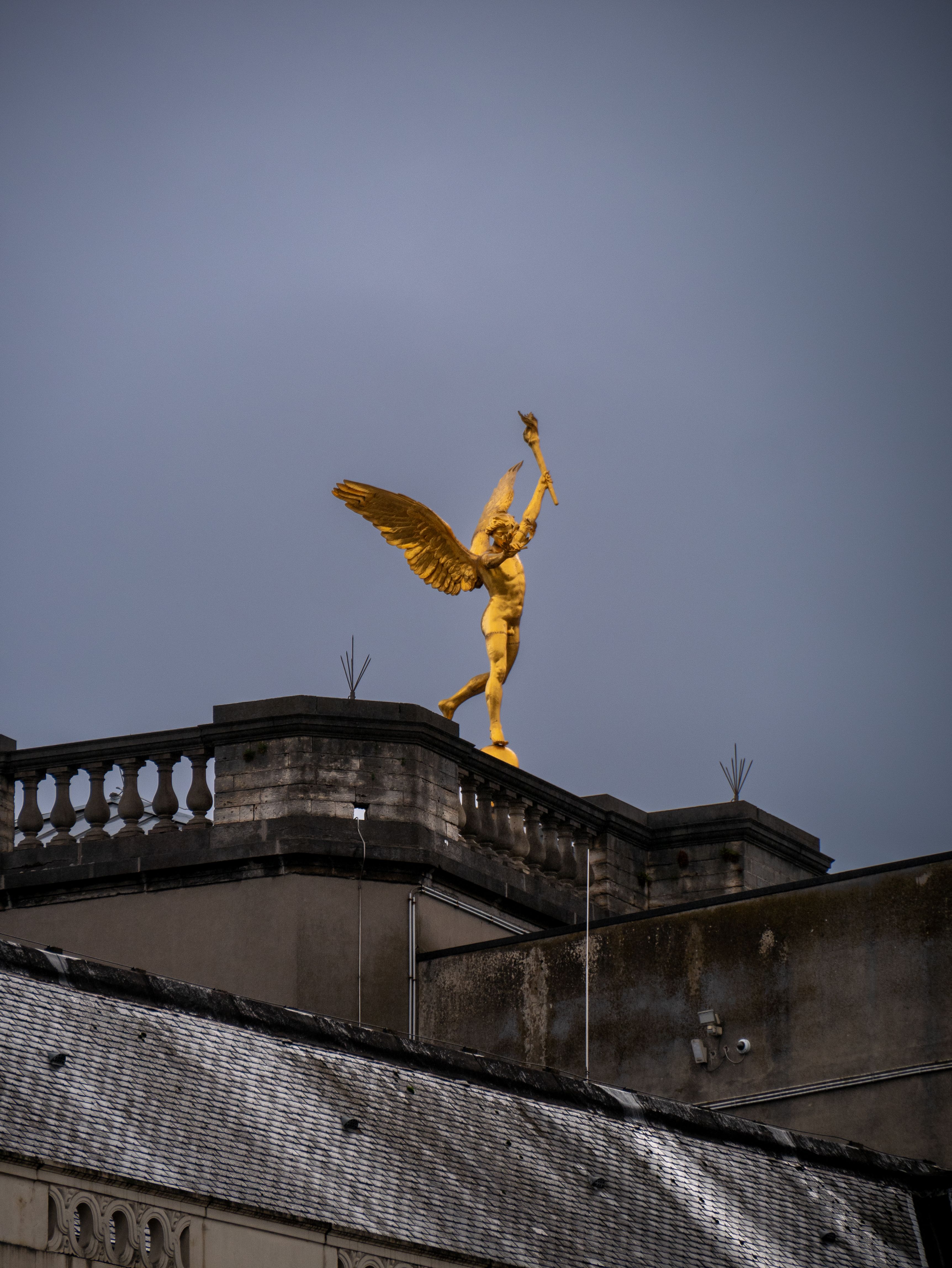 Golden Statue atop Historical Building under Cloudy Sky · Free Stock Photo