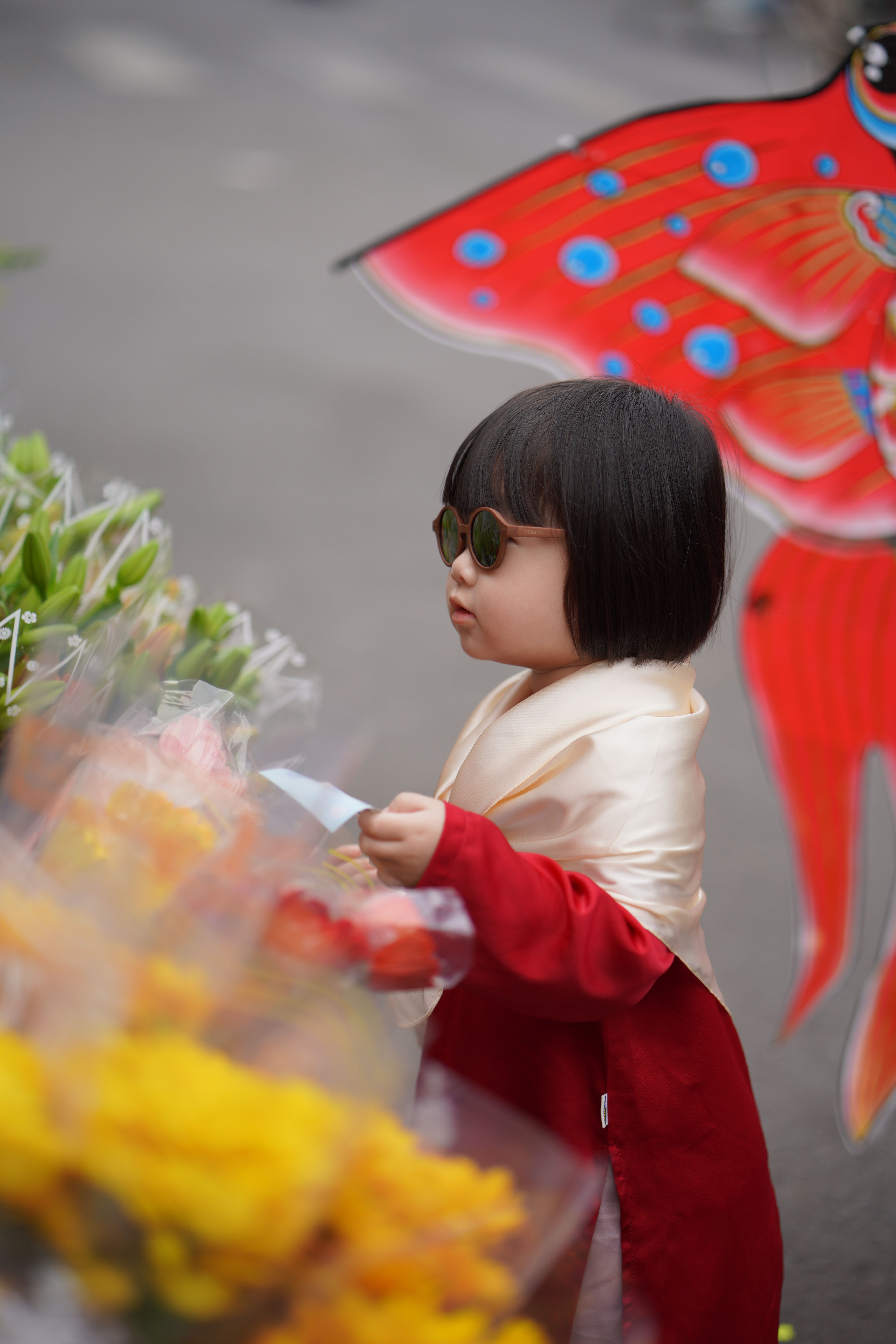 Child in Traditional Outfit with Kite and Flowers · Free Stock Photo