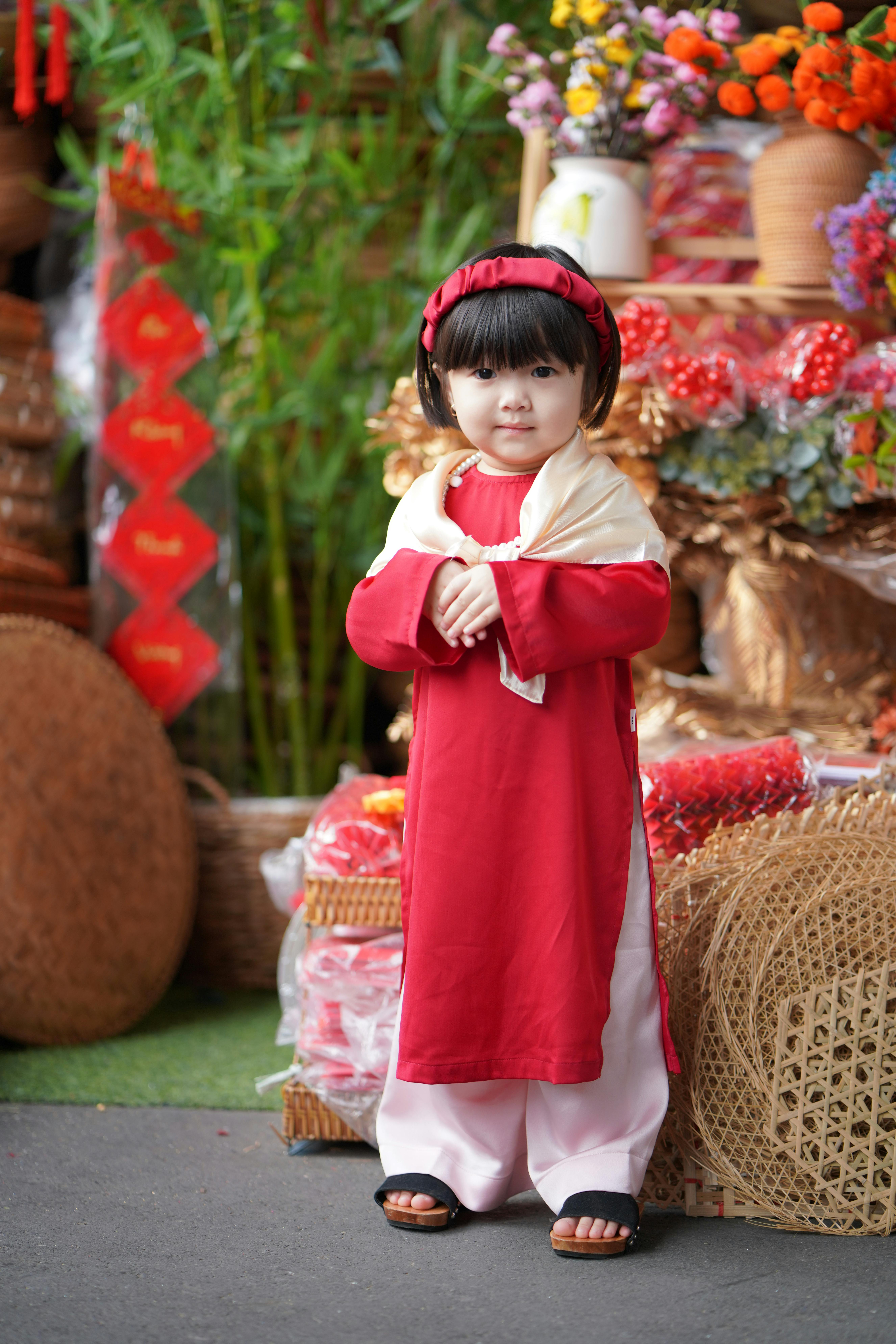 Child in Traditional Red Outfit with Spring Decor · Free Stock Photo