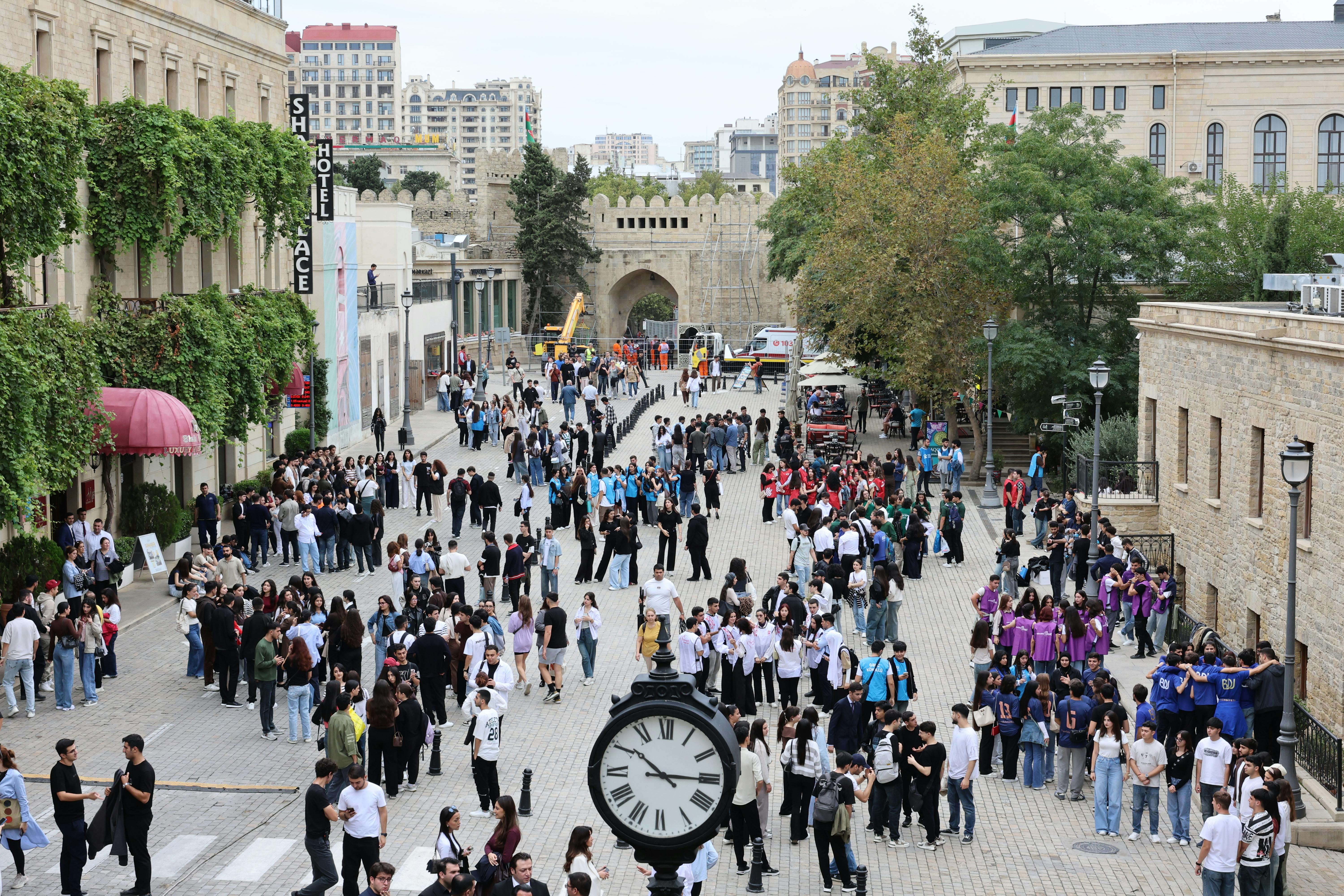 Vibrant Street Gathering Near Historic Gates · Free Stock Photo