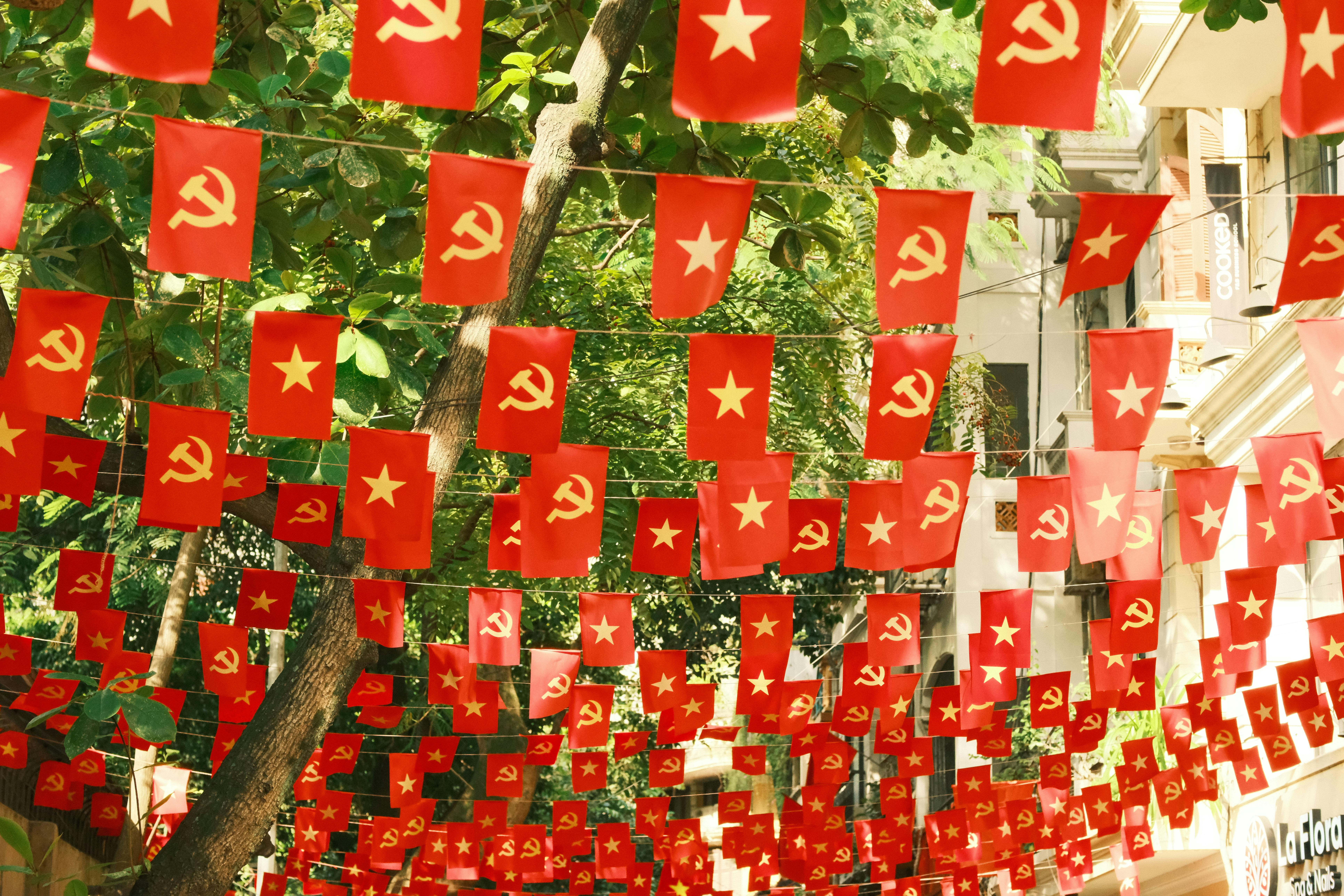 Red Communist Flags Hanging Outdoors · Free Stock Photo