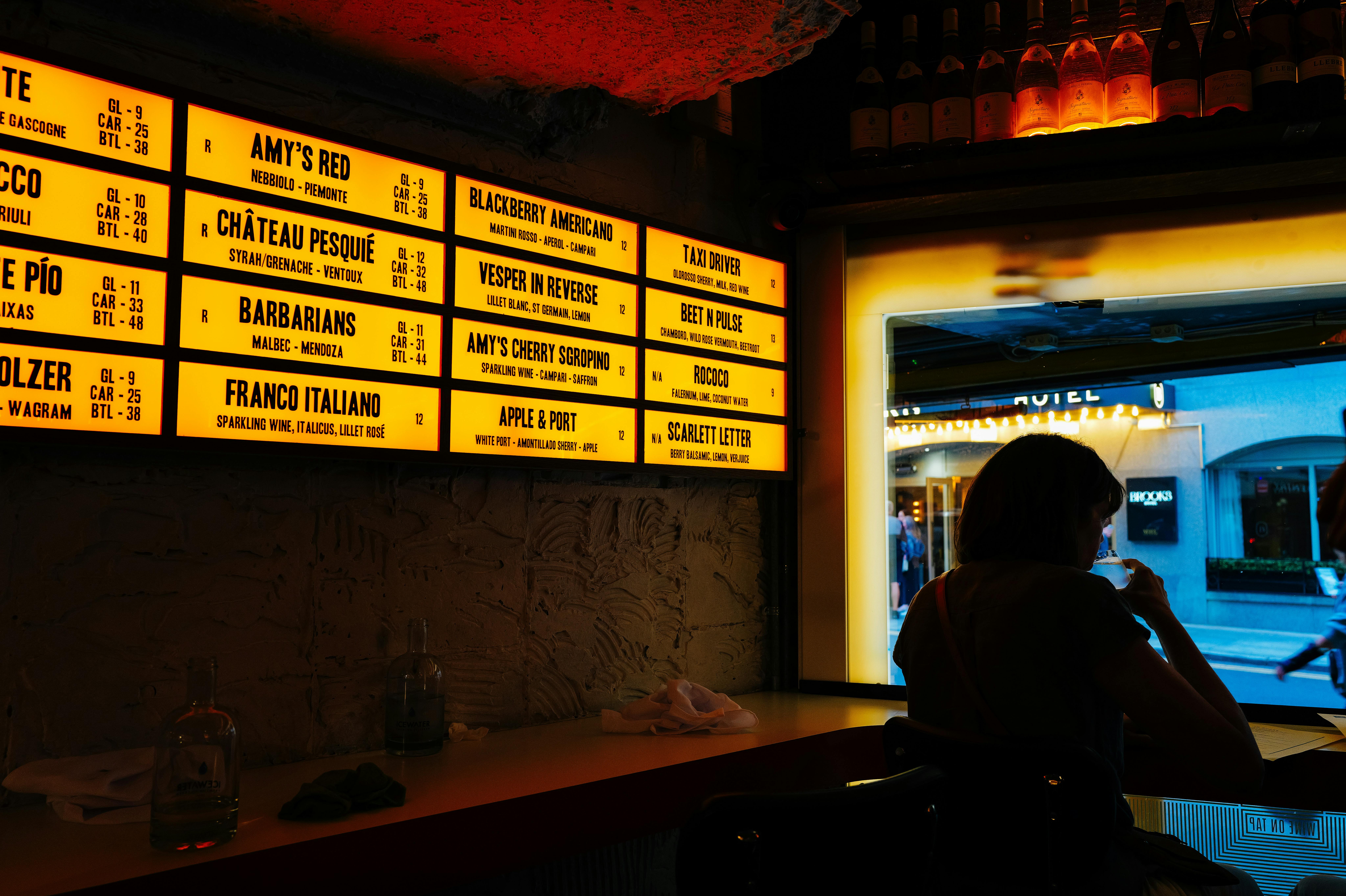 Cozy Wine Bar with Illuminated Menu at Night · Free Stock Photo