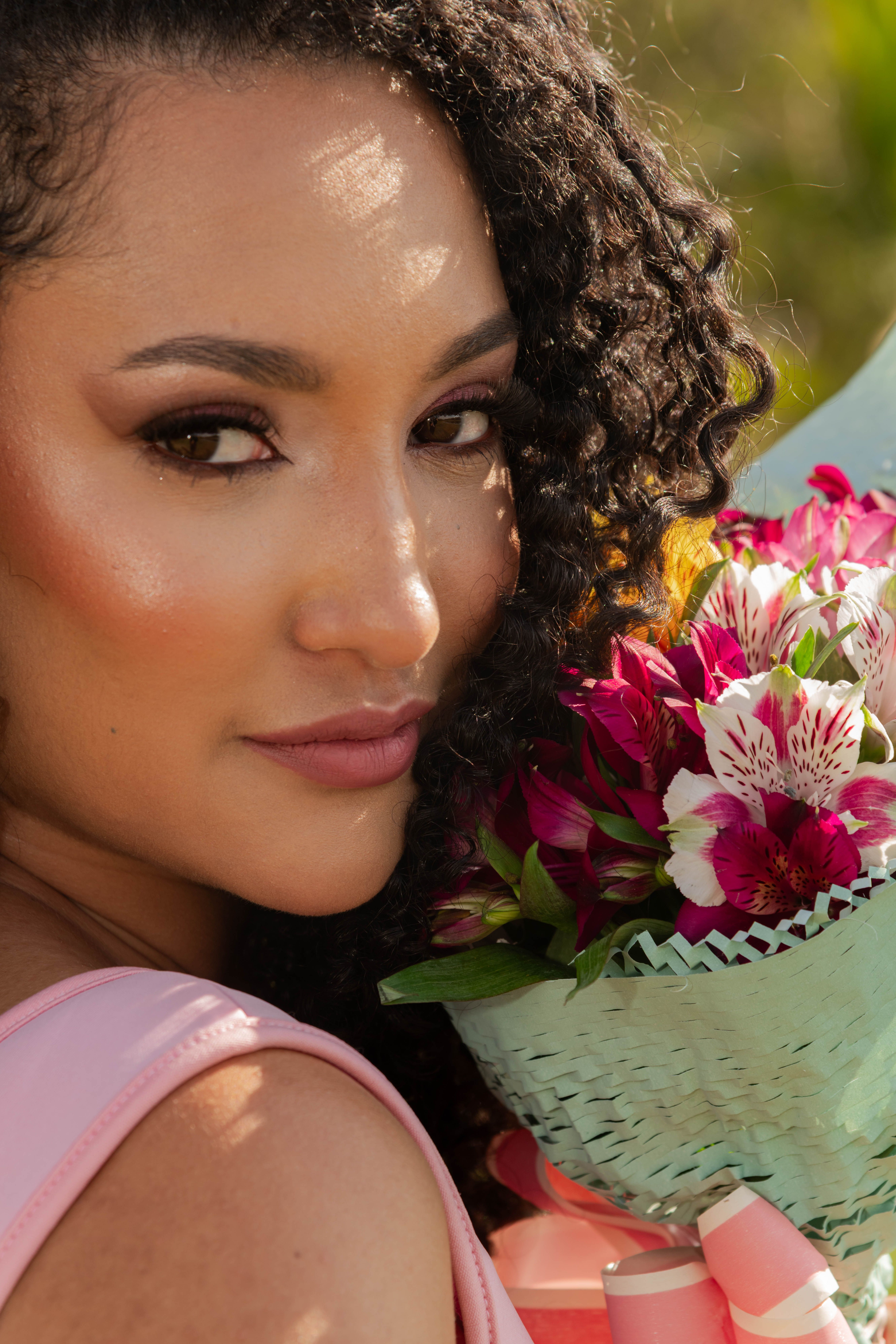 Woman with Curly Hair Holding Floral Bouquet · Free Stock Photo