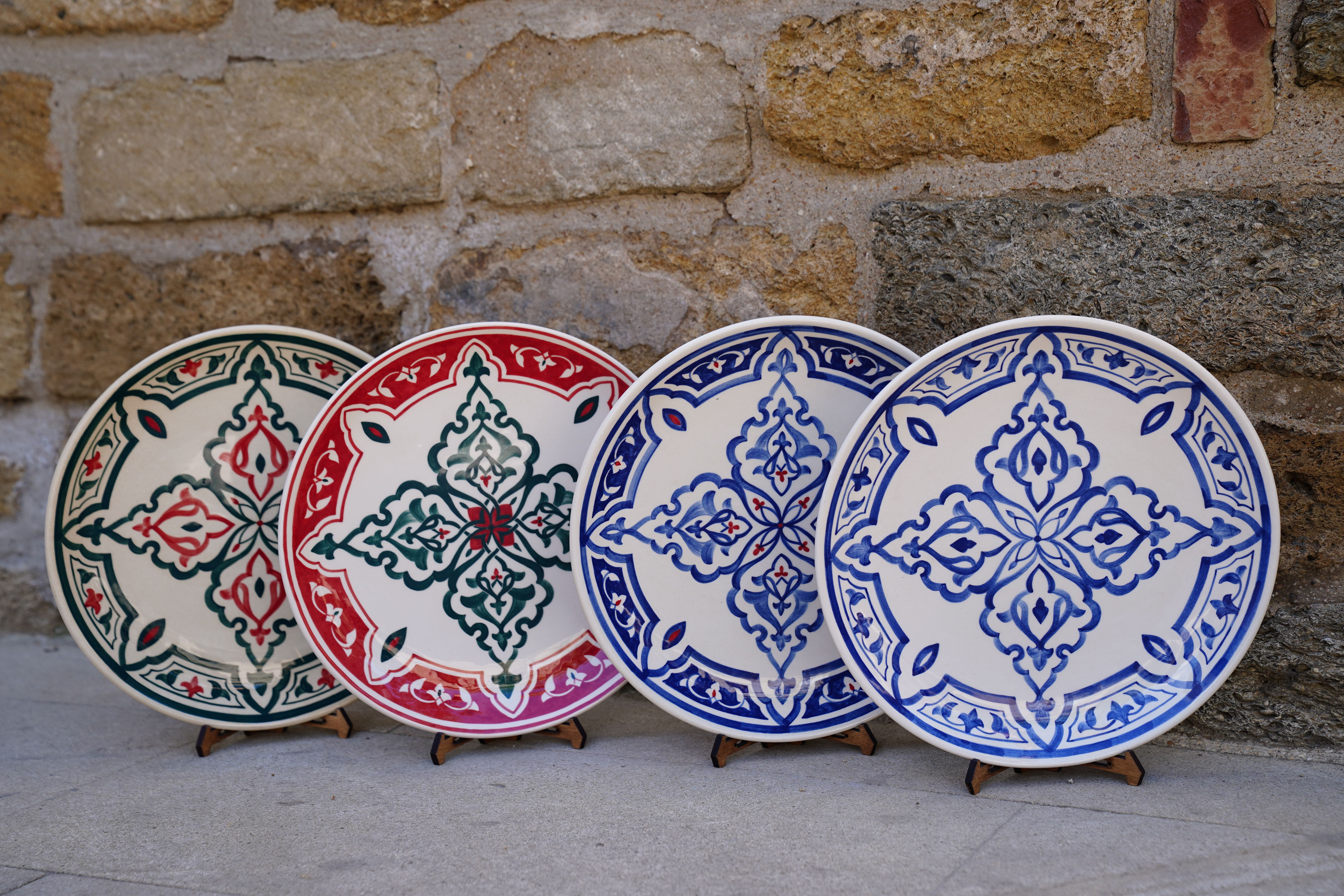 Colorful Handpainted Ceramic Plates on Stone Wall · Free Stock Photo