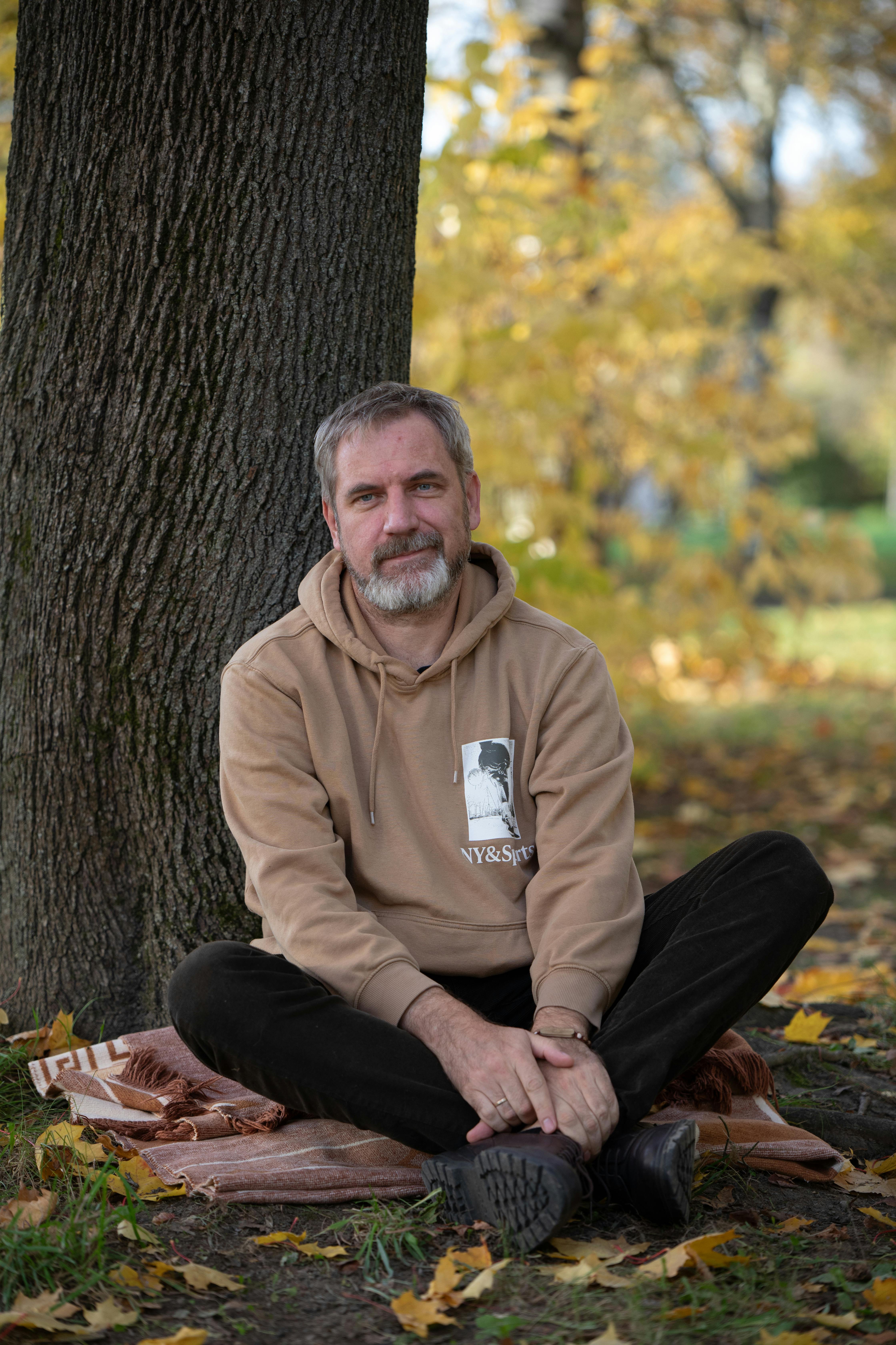 Man Relaxing Under Tree in Autumn Park · Free Stock Photo