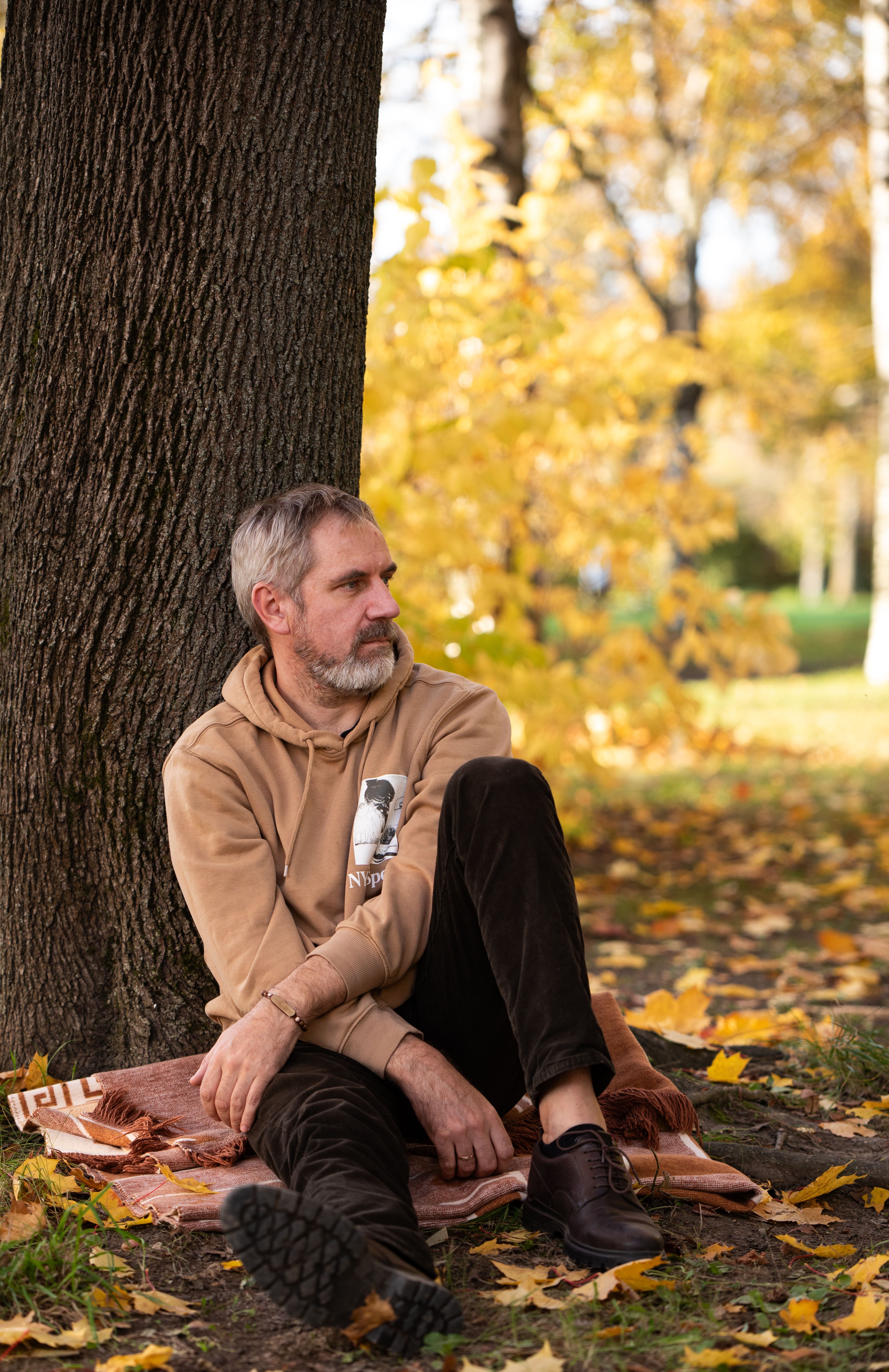 Man Relaxing Under Tree in Autumn Park · Free Stock Photo