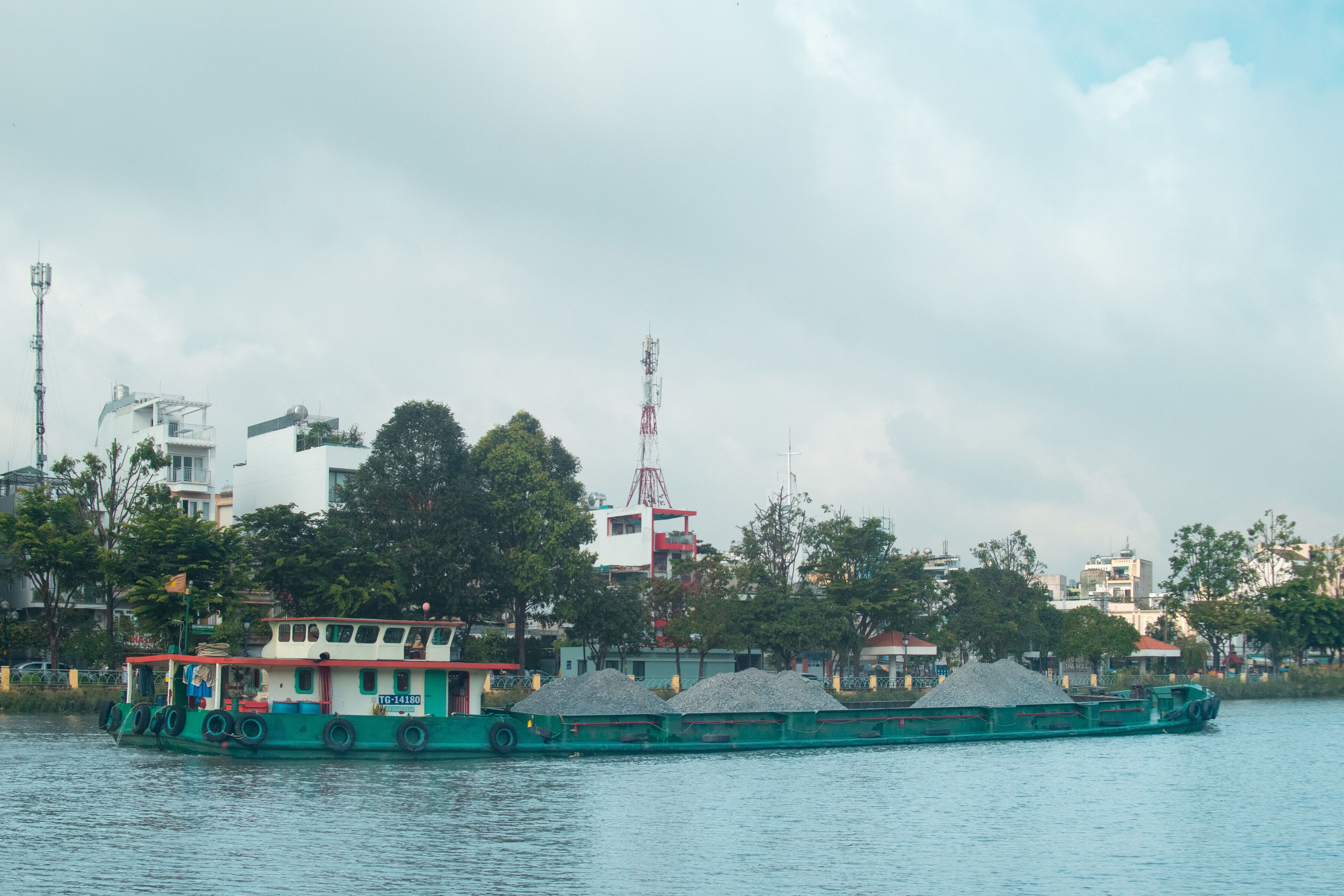 Barge Transporting Gravel on Urban River · Free Stock Photo