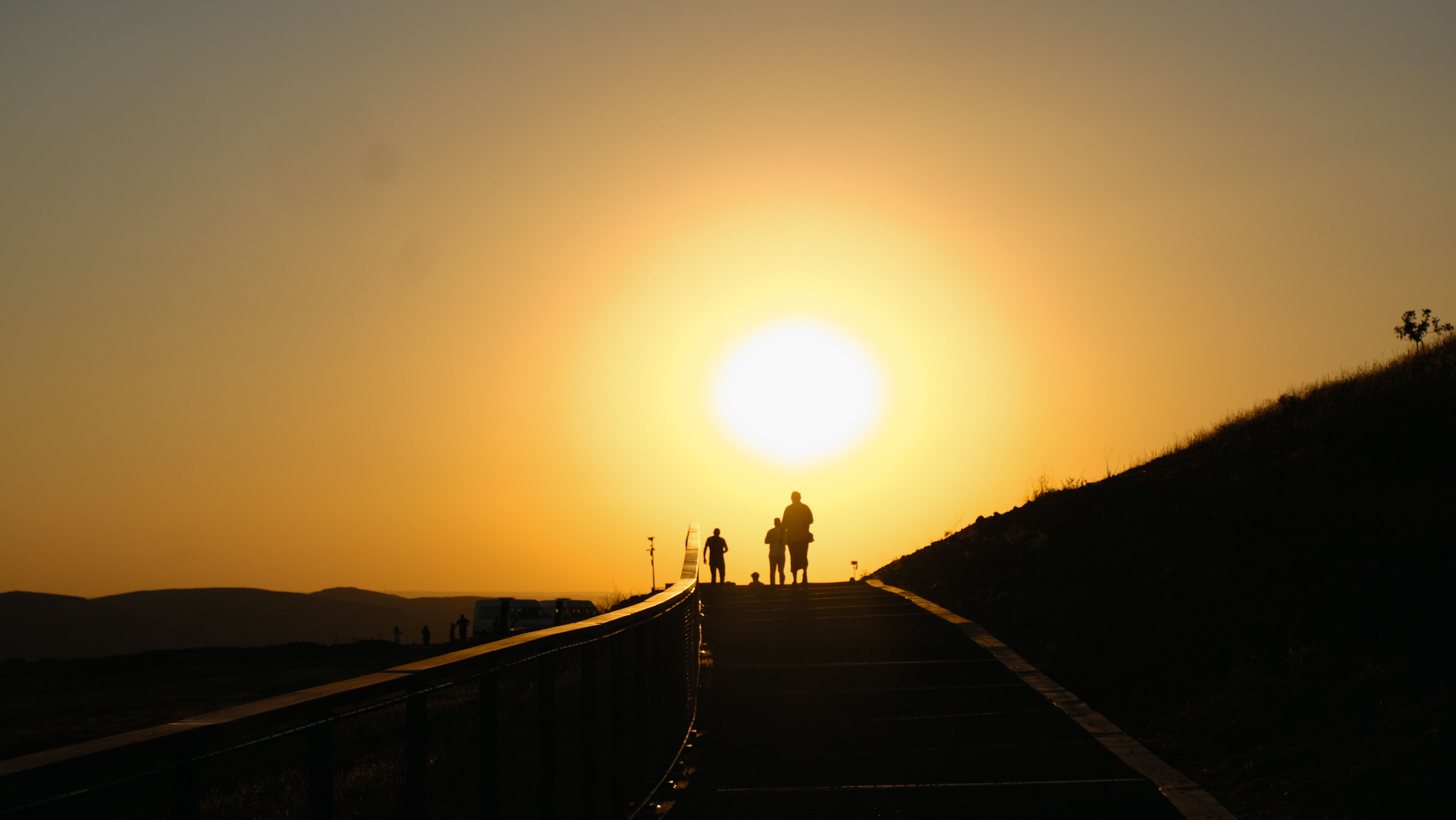 Silhouetted Figures Walking at Sunset · Free Stock Photo