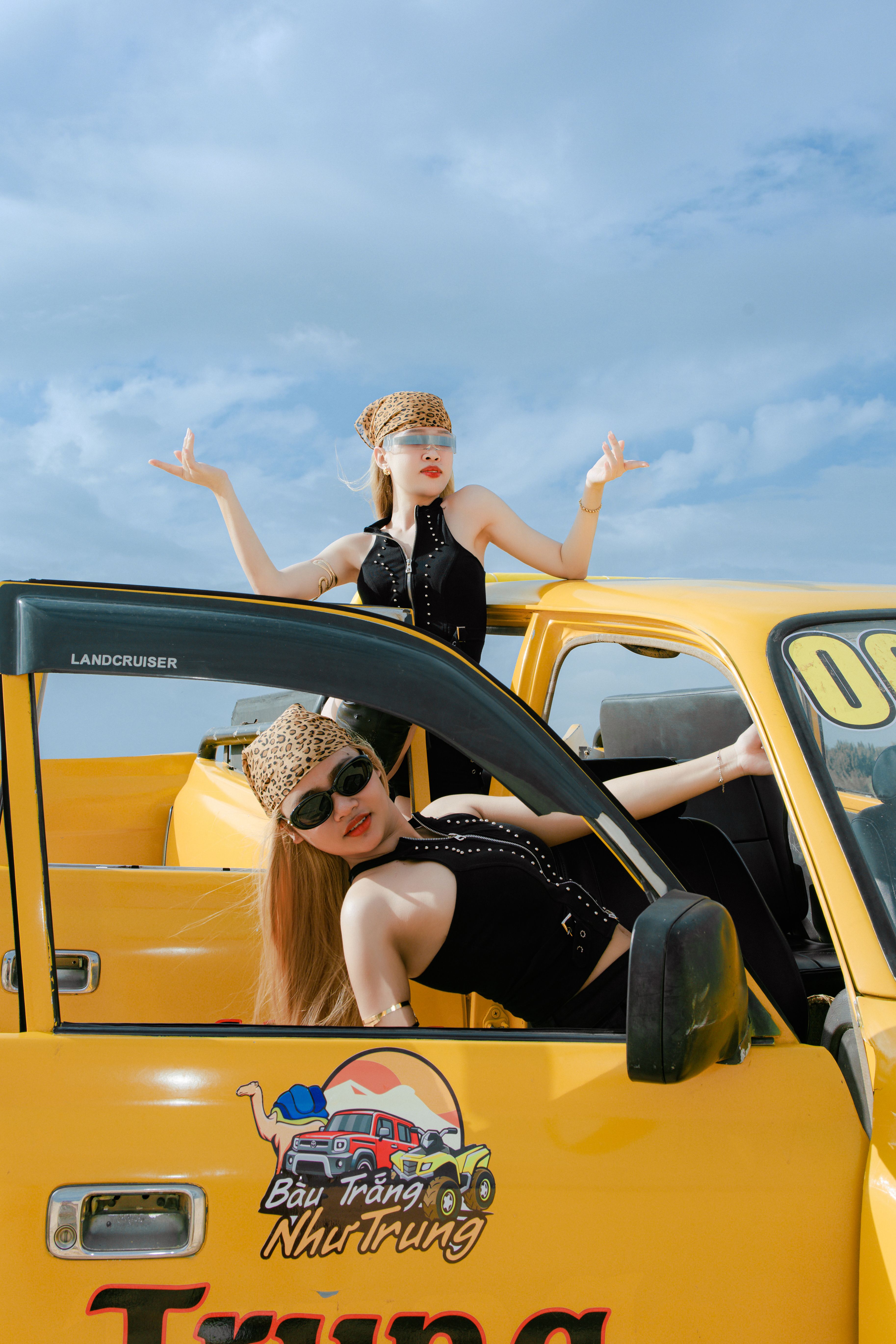 Stylish Women Posing in Yellow Jeep Outdoors · Free Stock Photo