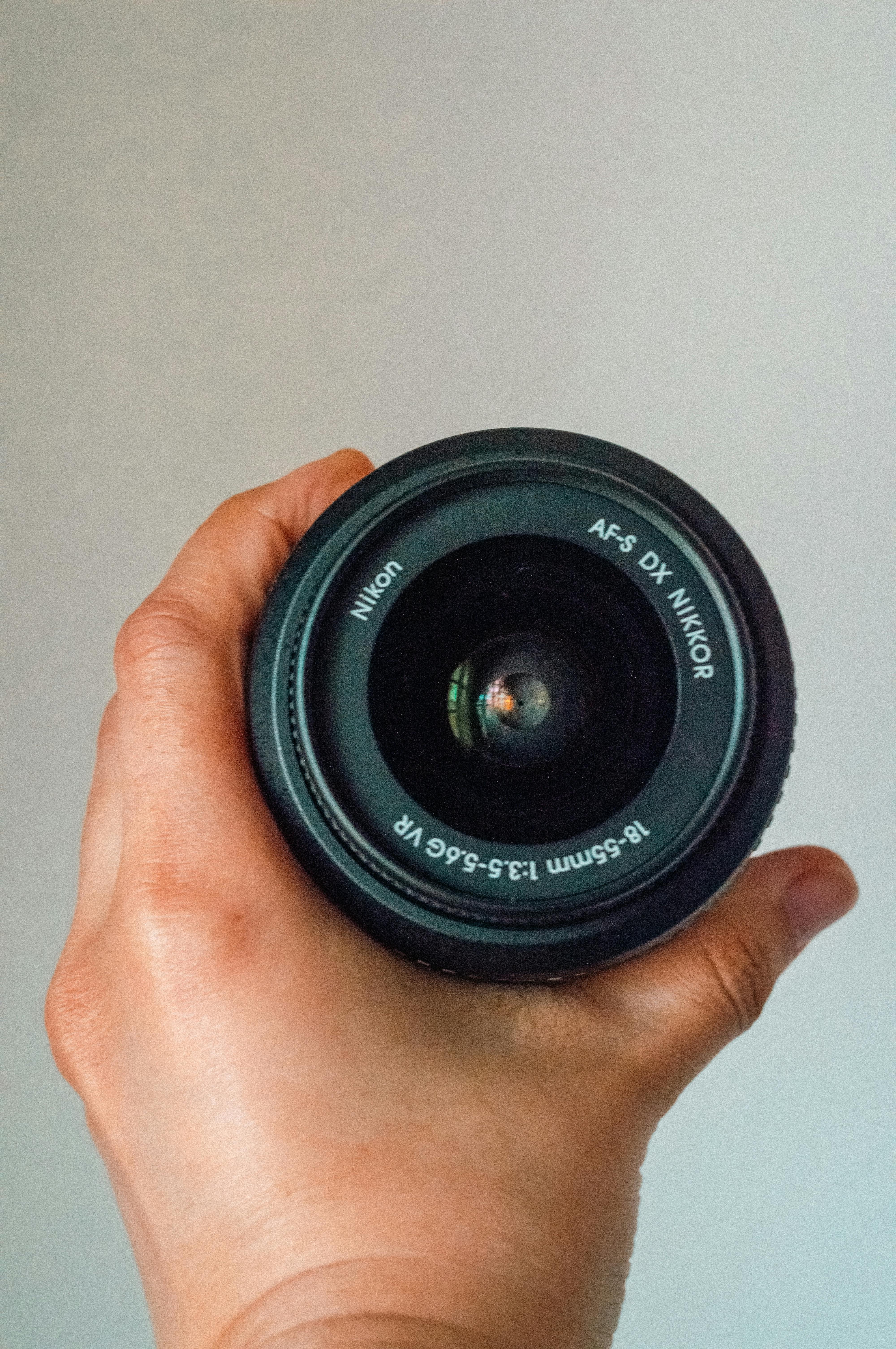 Close-up of Hand Holding Camera Lens · Free Stock Photo