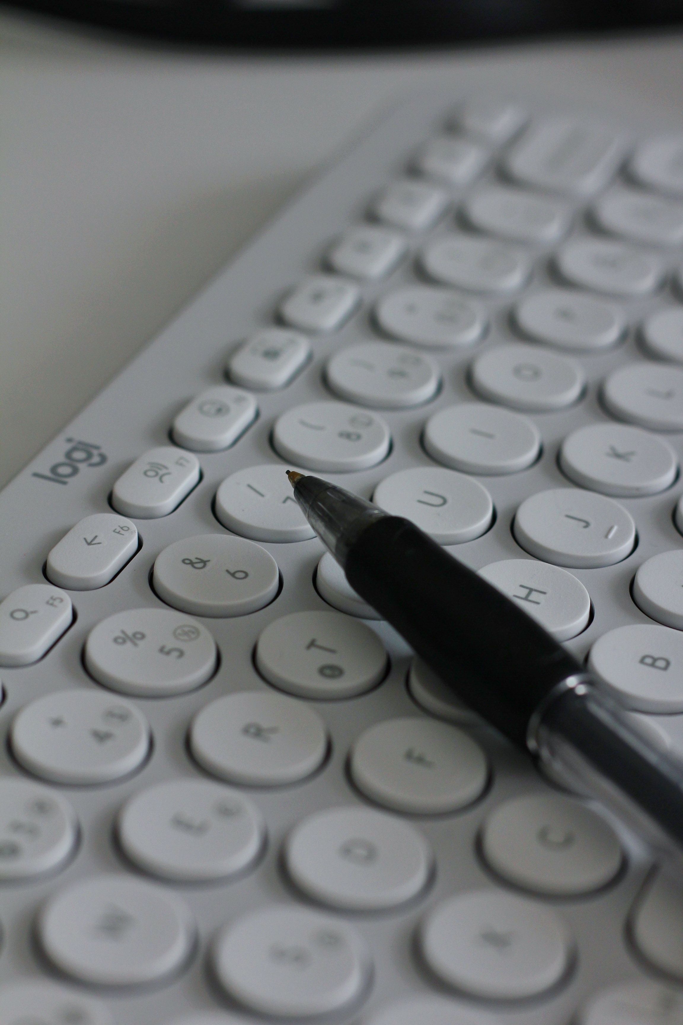 Close-Up of White Keyboard with Pen for Office Use · Free Stock Photo
