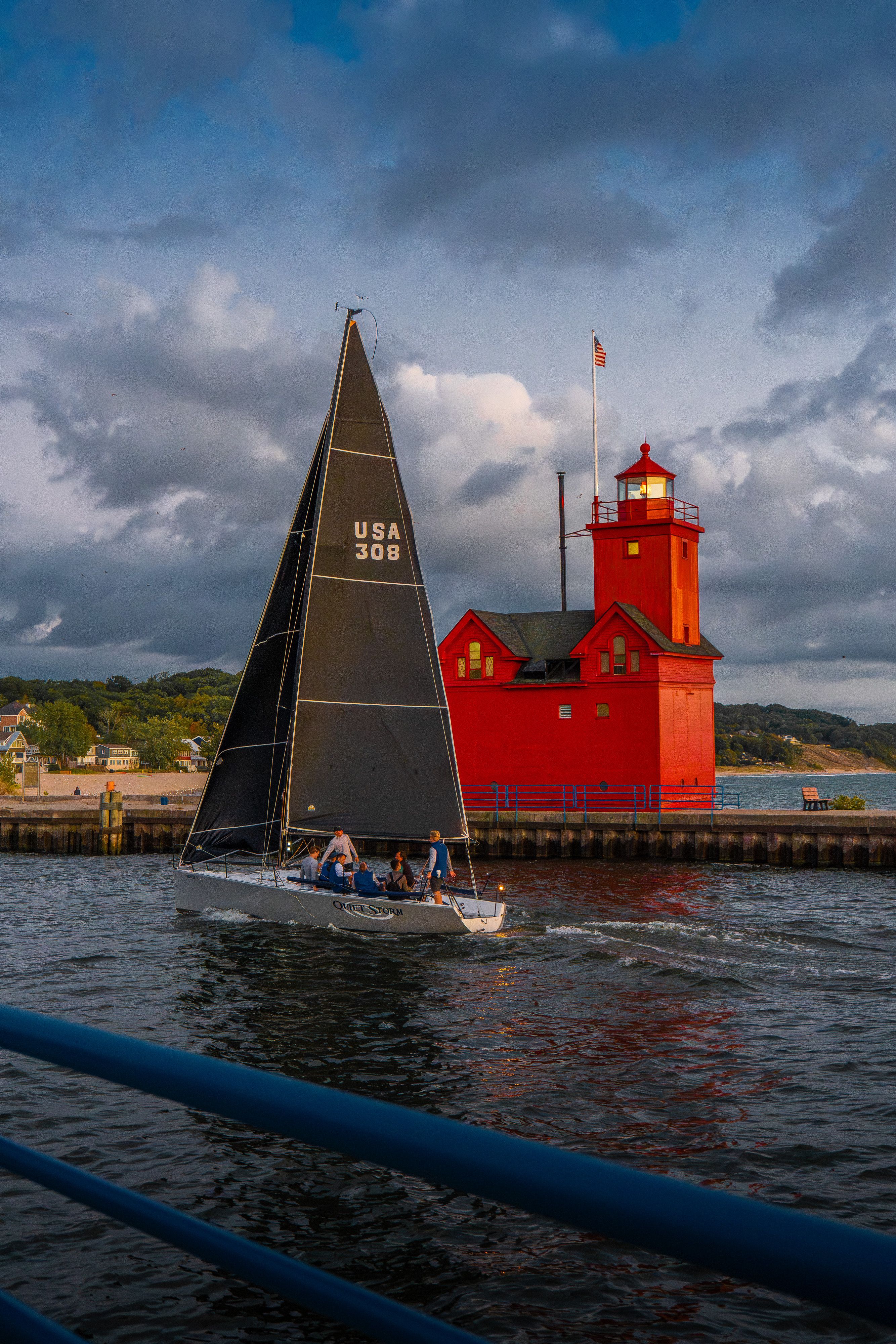 Sailboat Passing Holland Harbor Lighthouse at Sunset · Free Stock Photo