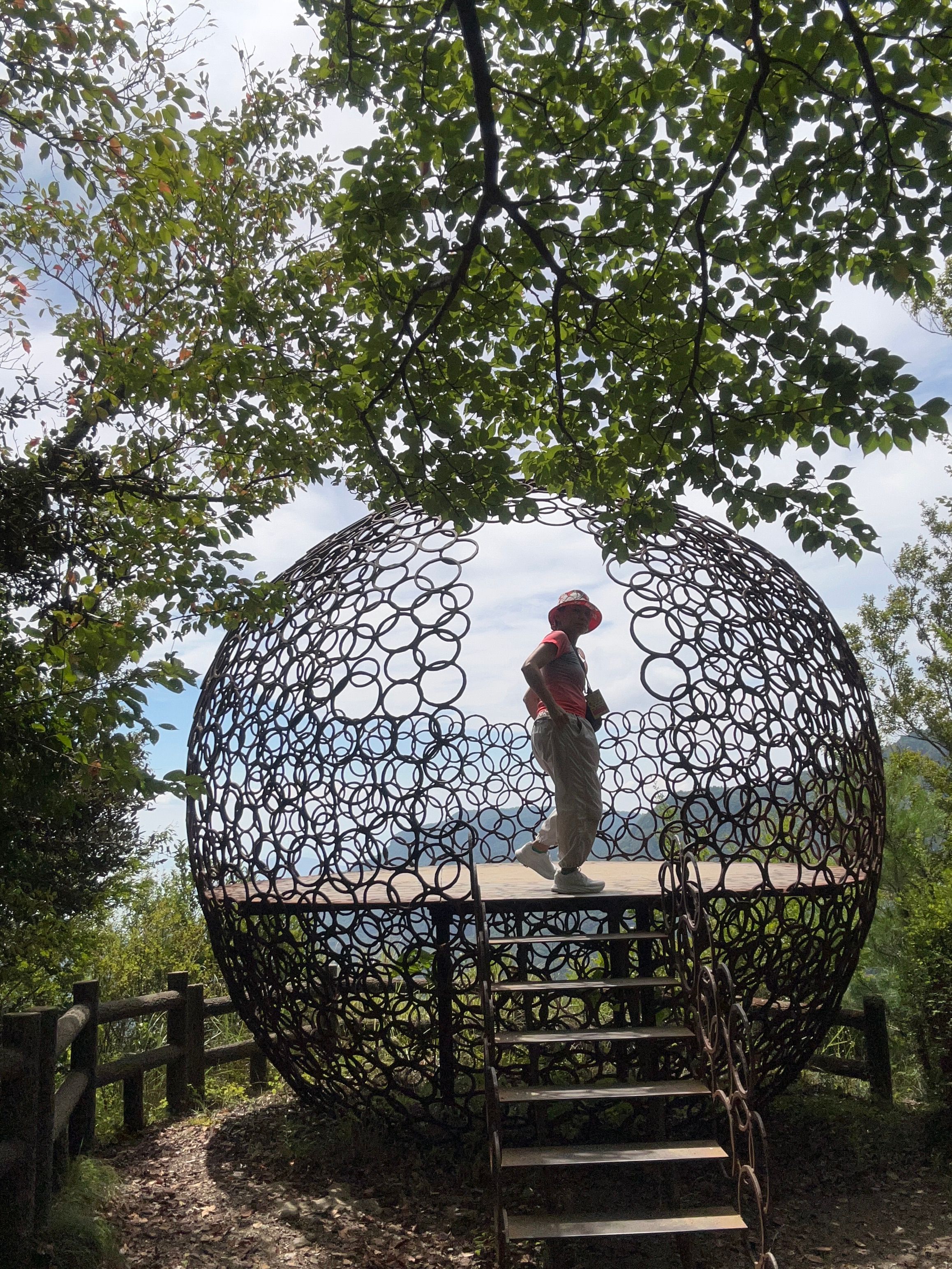Person Standing Inside Artistic Metal Sphere · Free Stock Photo