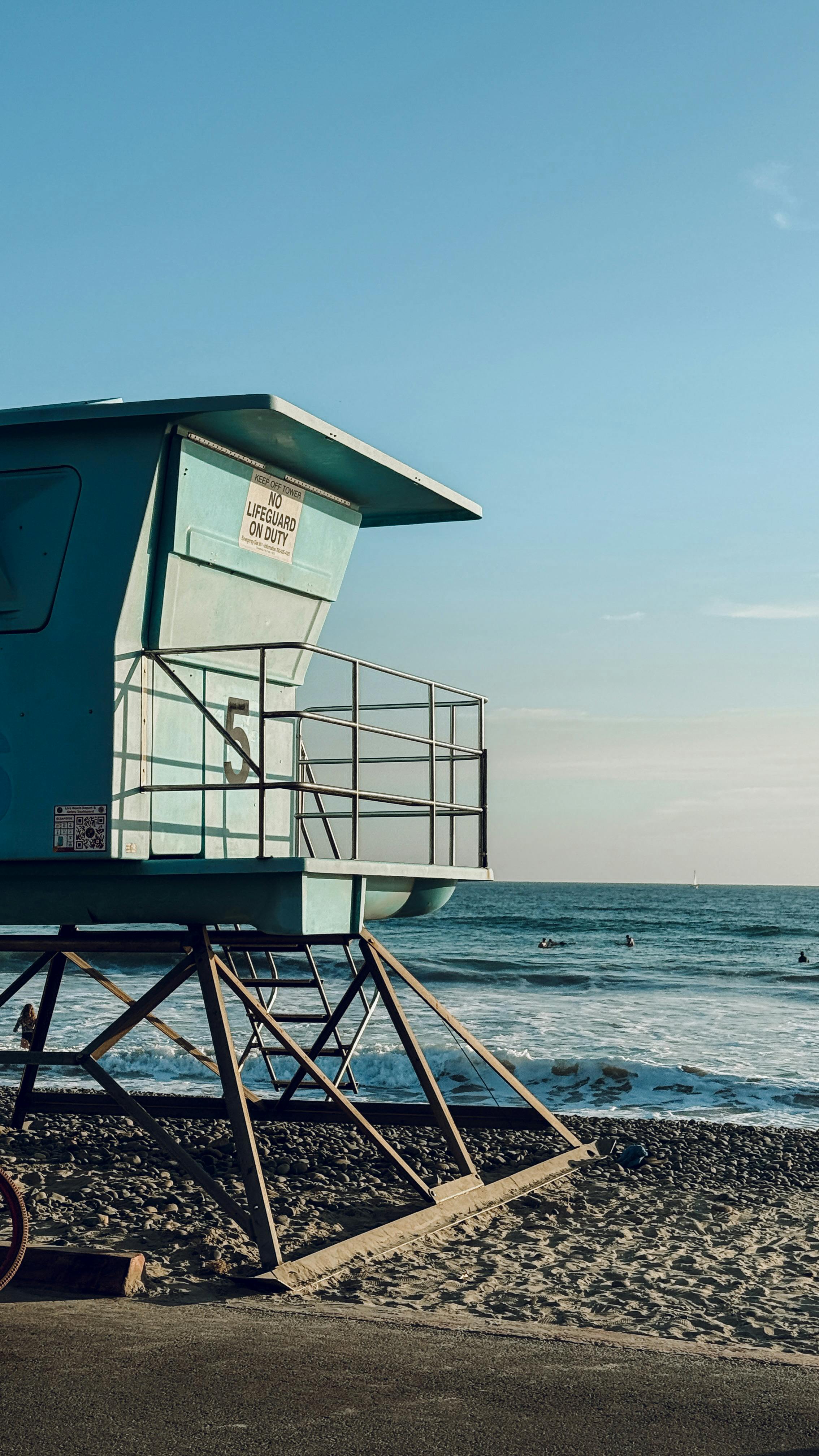 Lifeguard building on seashore against sundown sky · Free Stock Photo