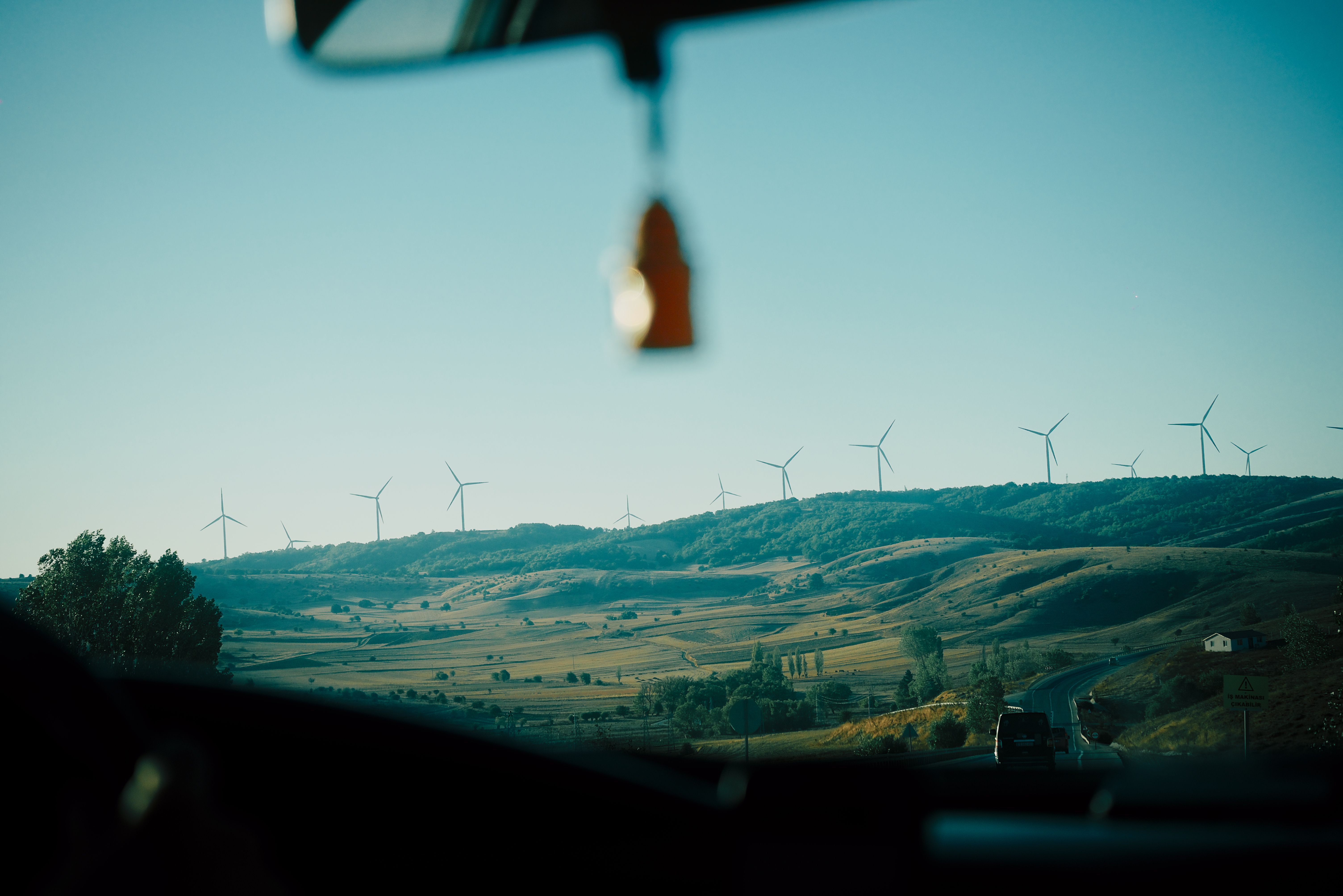 Scenic Drive with Wind Turbines and Open Fields · Free Stock Photo