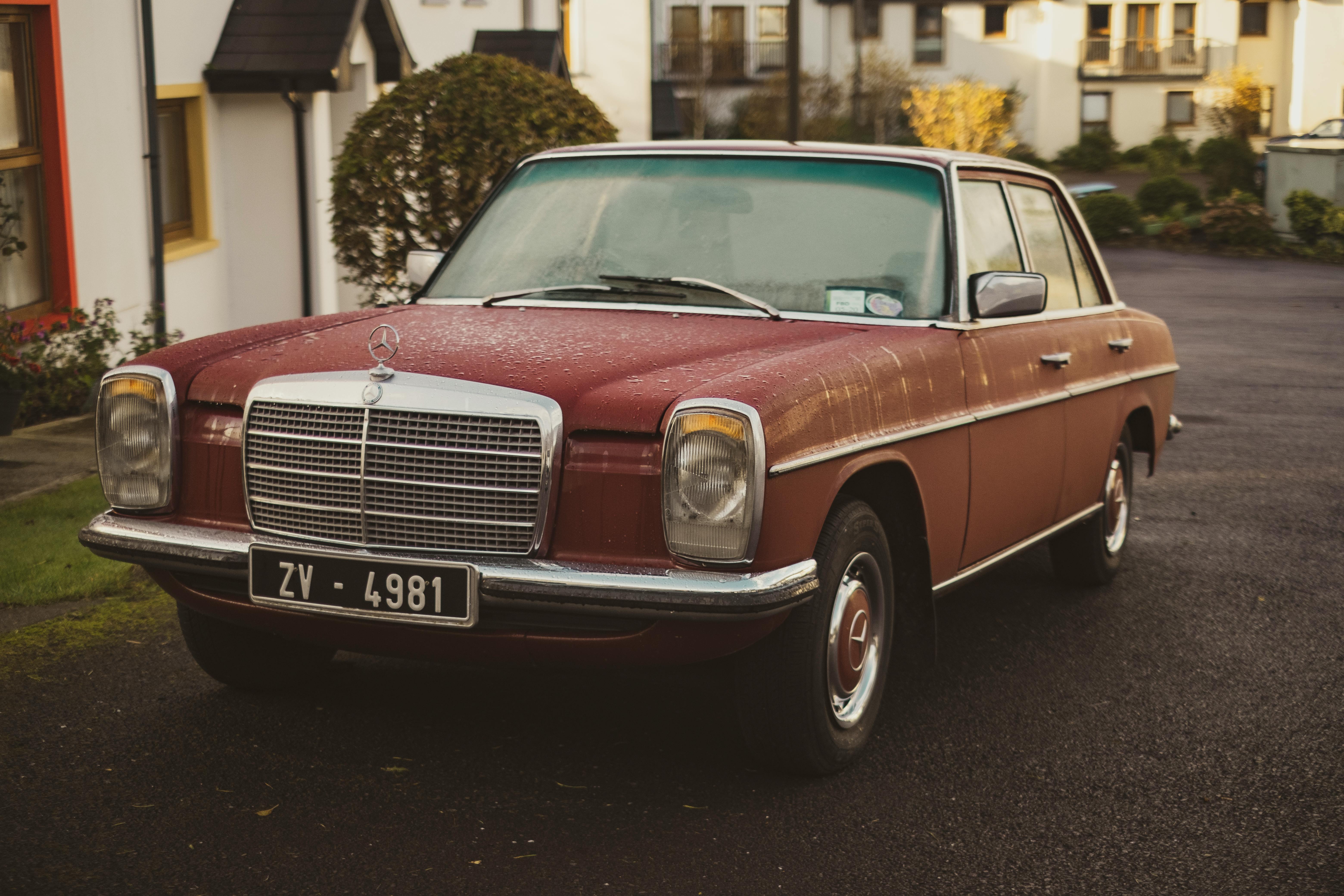 Red Mercedes-benz W114 Sedan Parking Near House · Free Stock Photo
