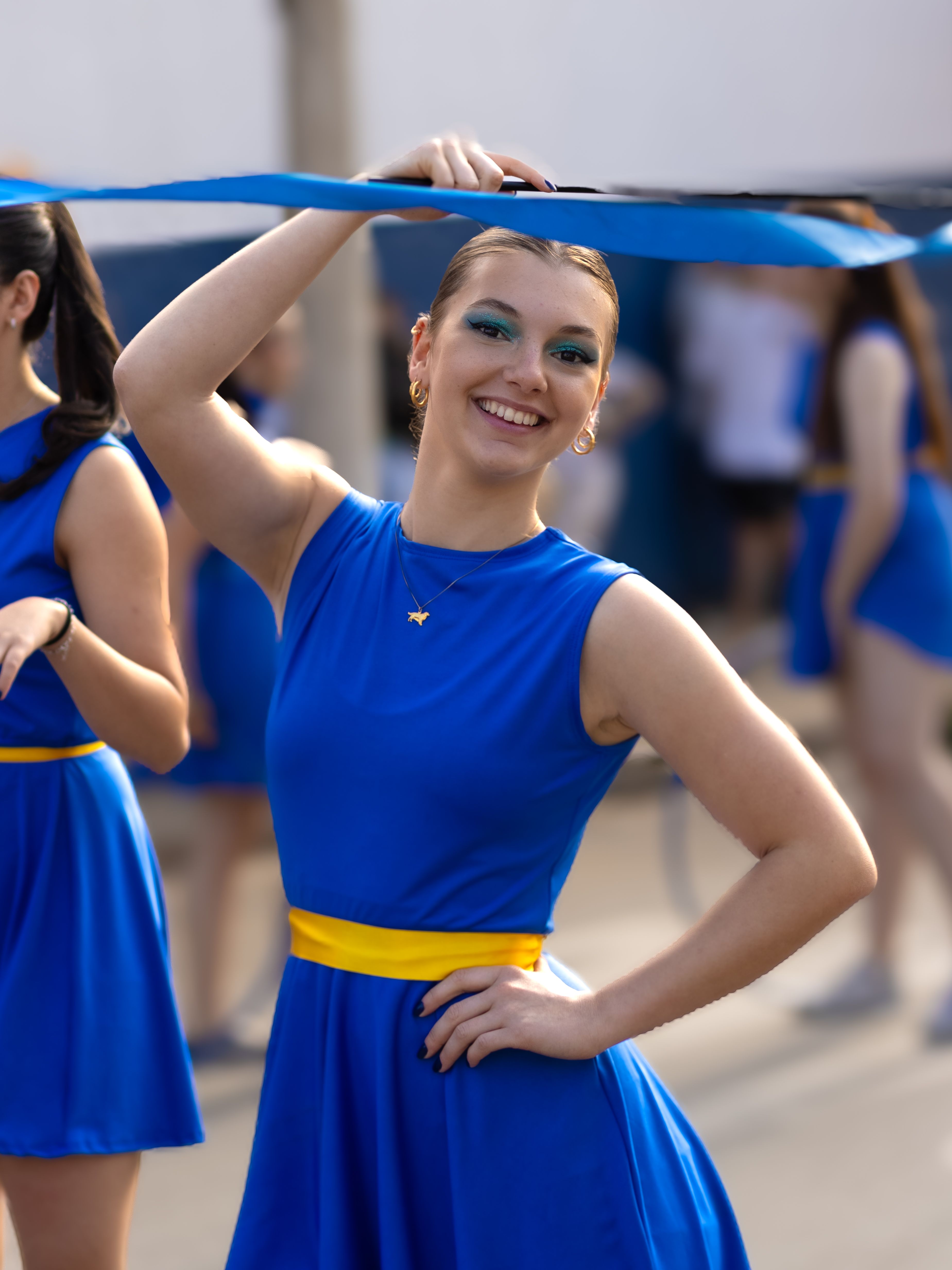 Smiling Cheerleader in Blue Uniform with Ribbon · Free Stock Photo