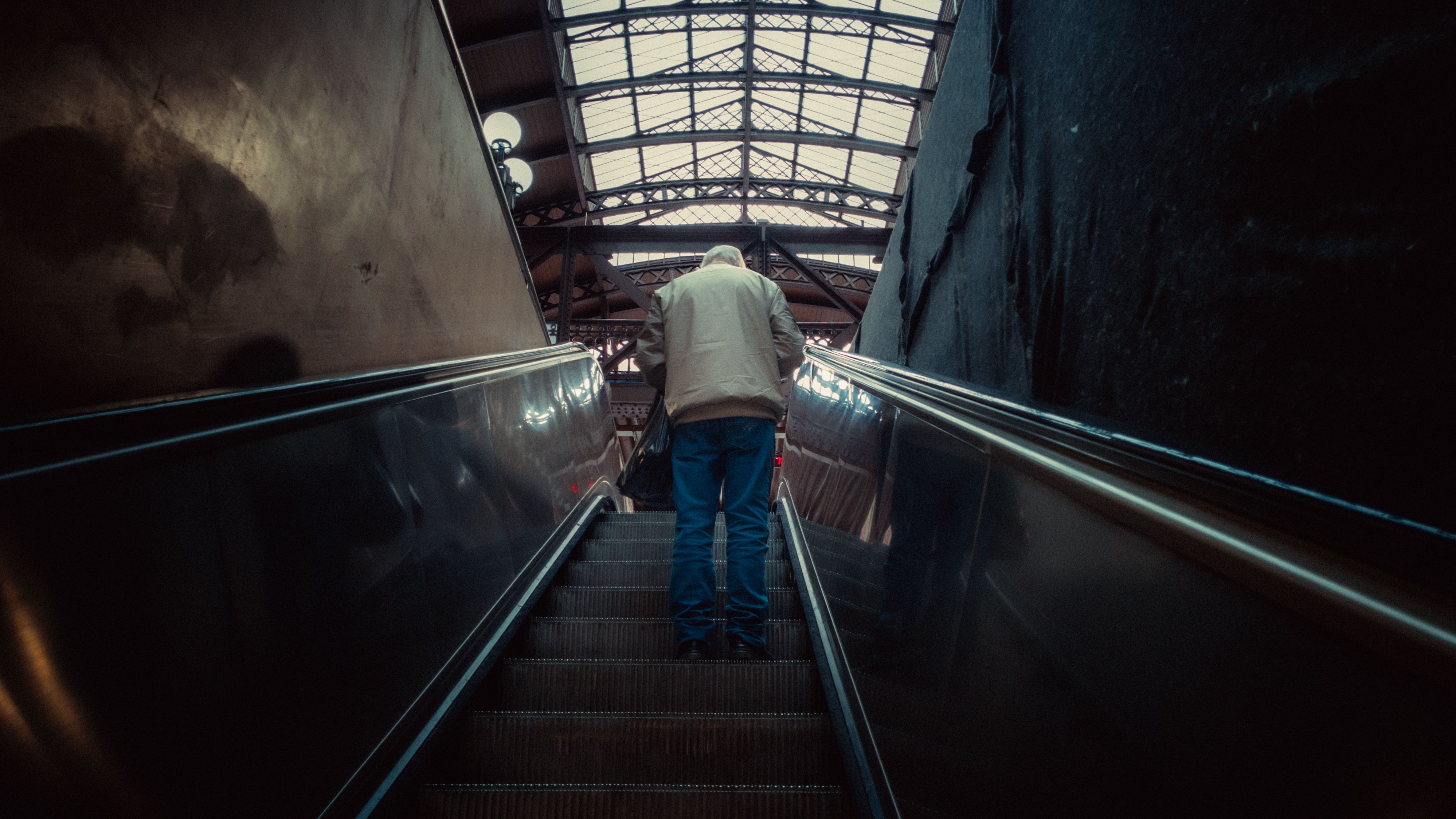 Man Ascending Escalator in Urban Setting · Free Stock Photo
