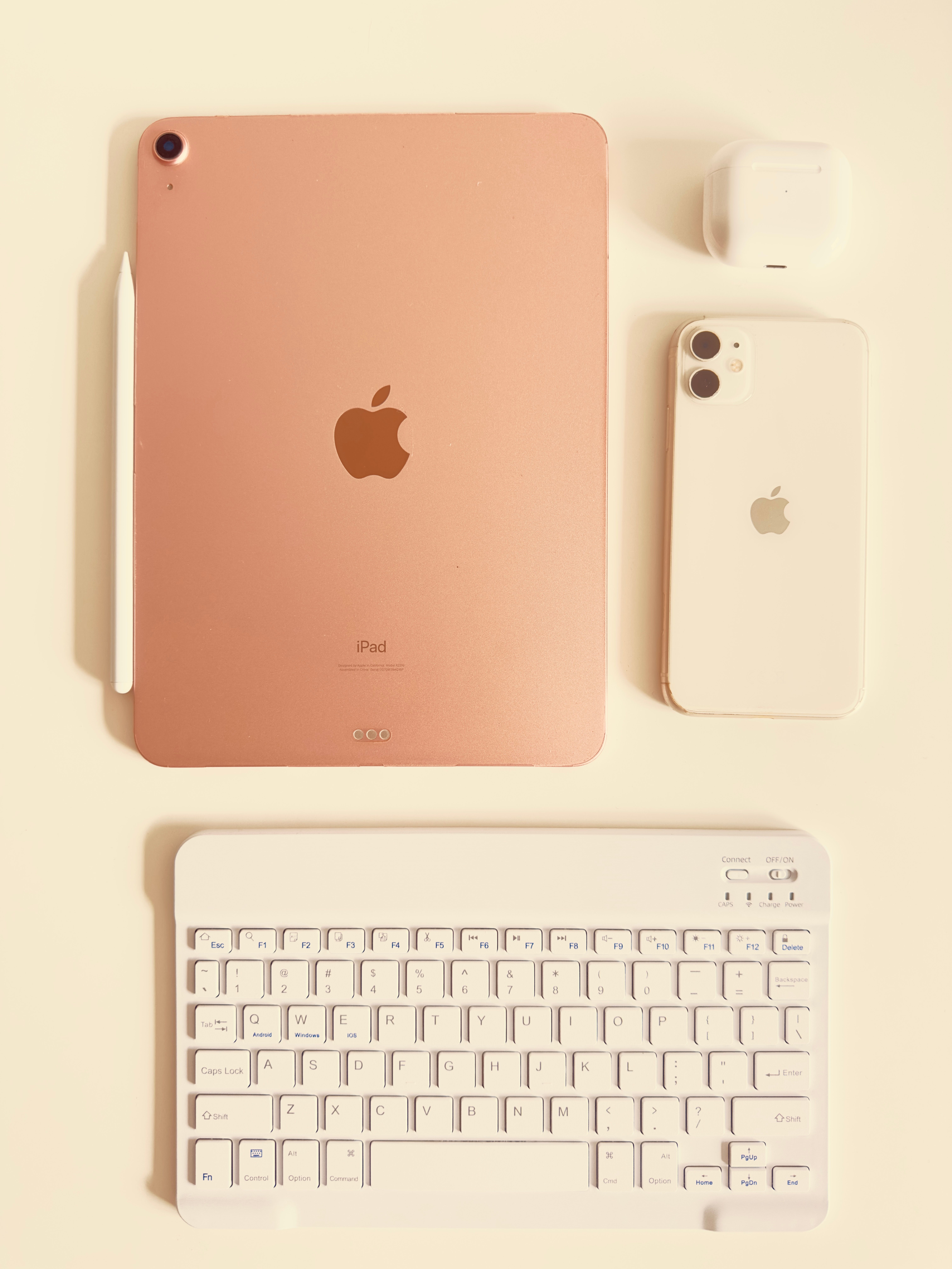 Flat Lay of Tech Gadgets Against Cream Background · Free Stock Photo